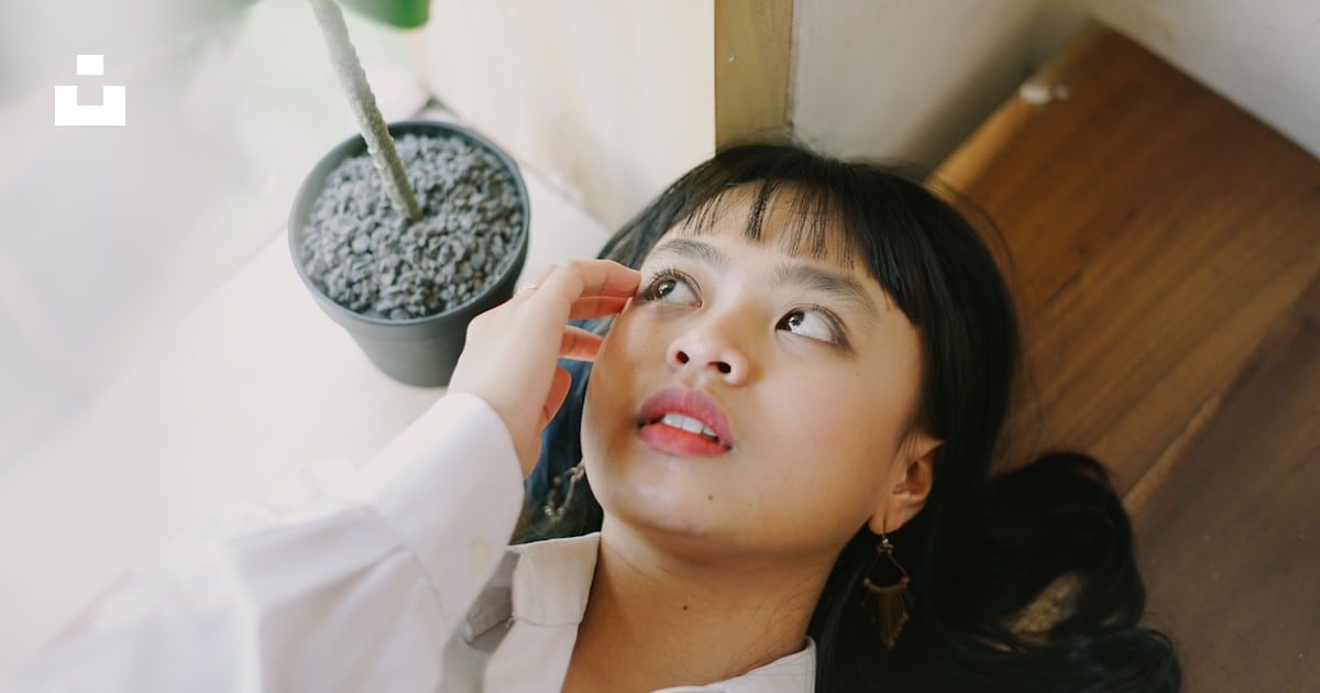 흰색 버튼 업 셔츠를 입은 소녀가 흰색 스마트폰을 들고 있다 사진 Unsplash의 무료 사진술 이미지