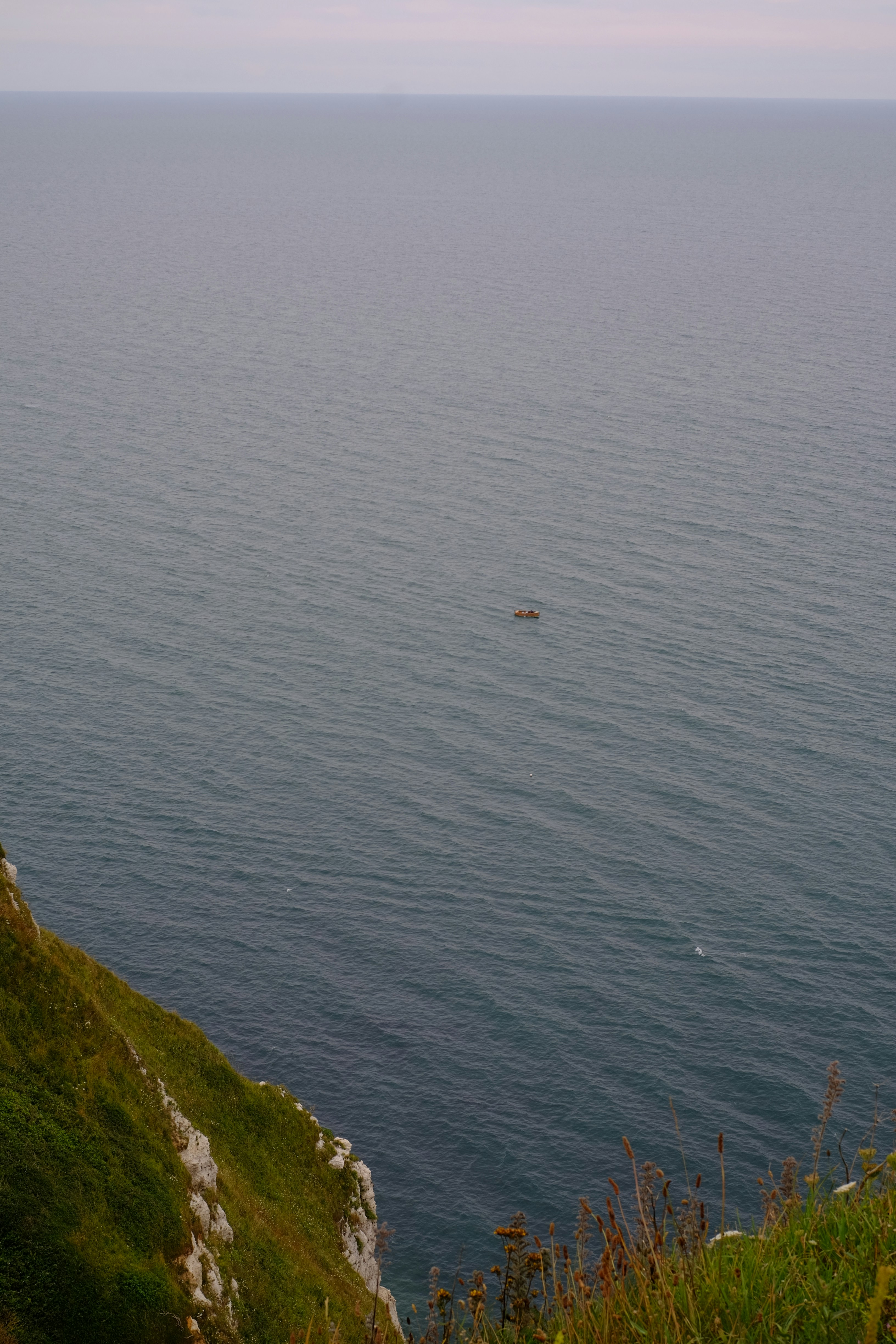 Vessel at the Edge: A Quiet Moment Along the Cliff's Line