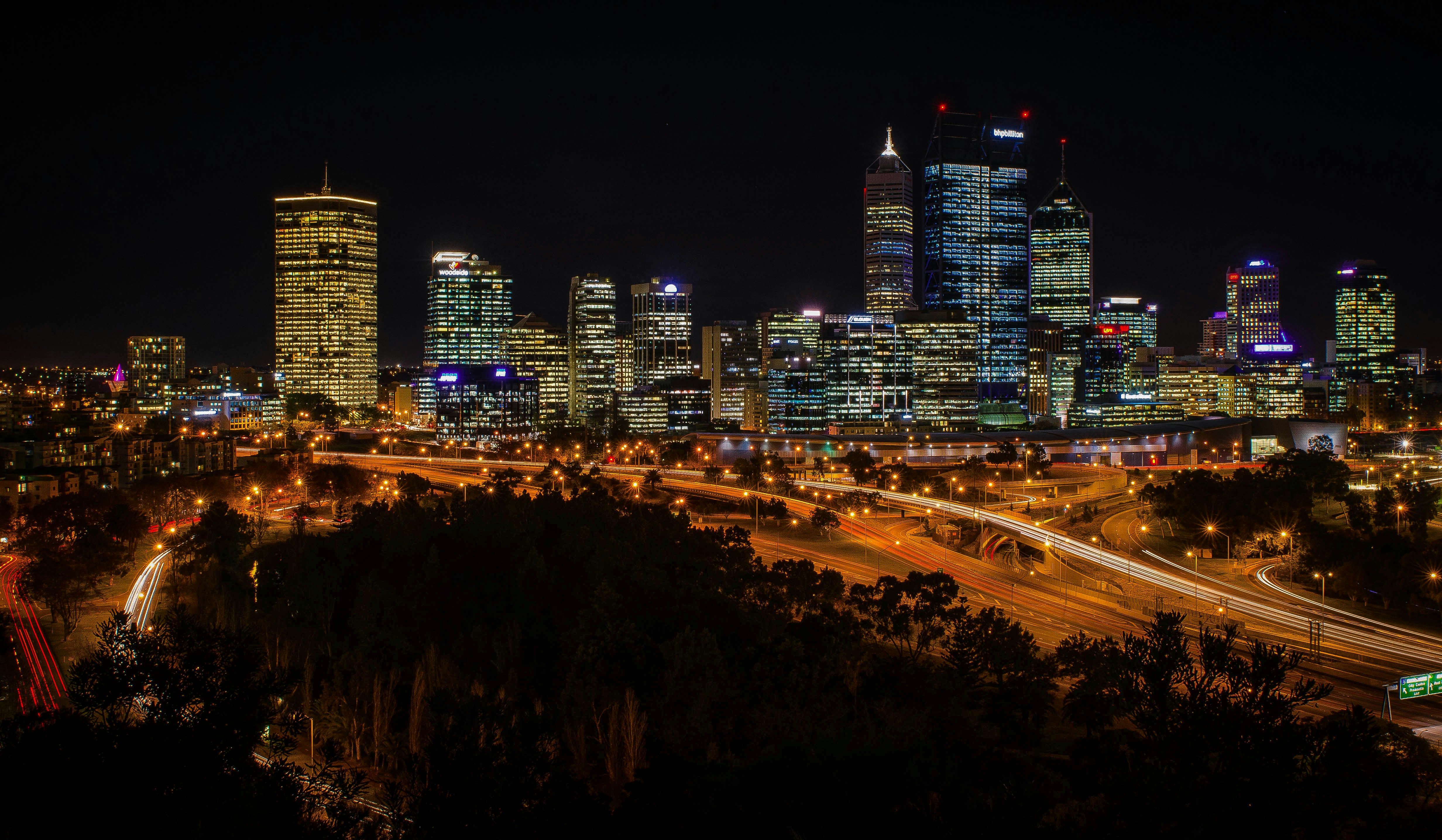 City skyline glowing with vibrant lights against a dark night sky.