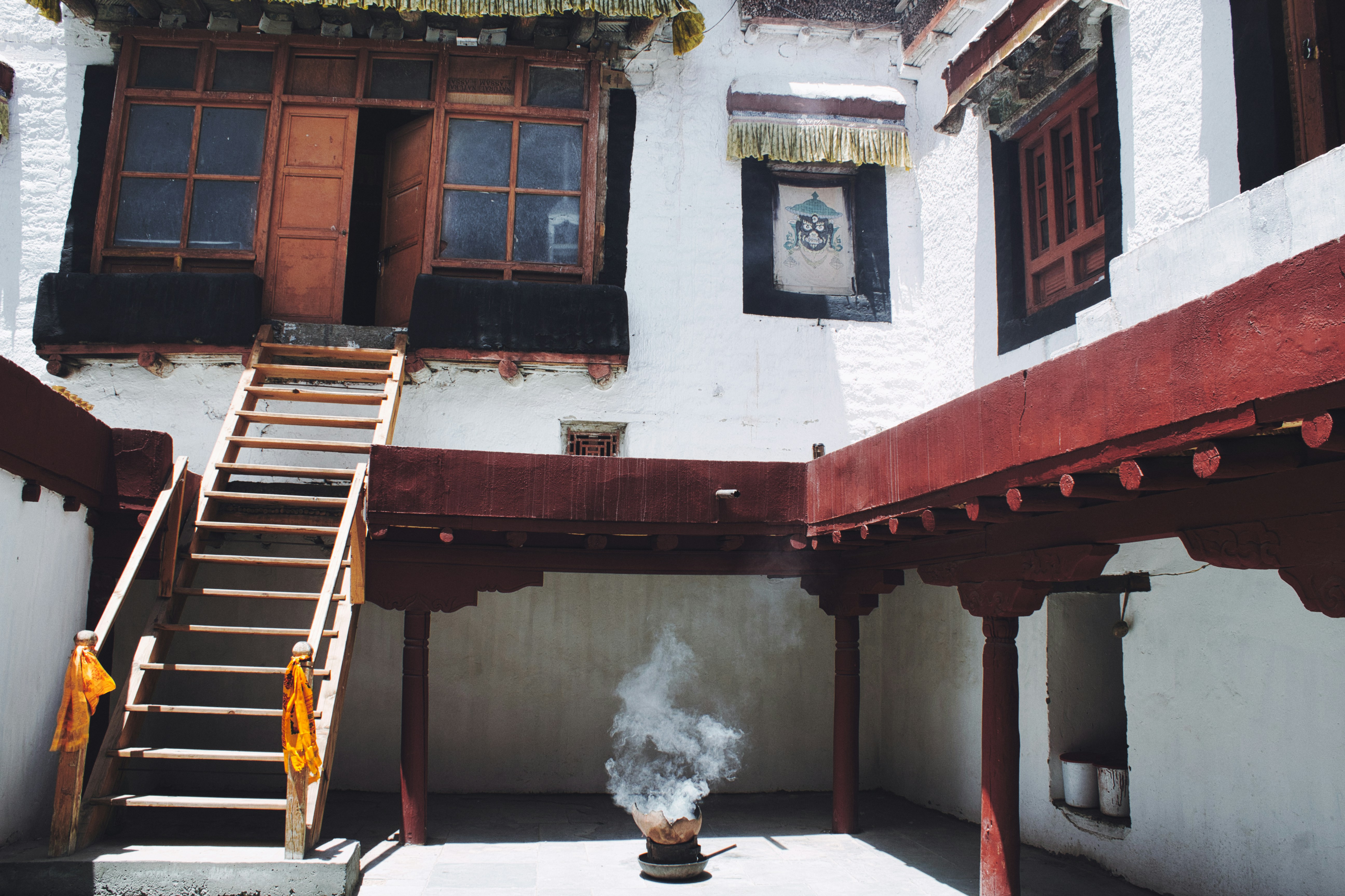 Censer Smoke in a White-Walled Courtyard Framed by Red Timber