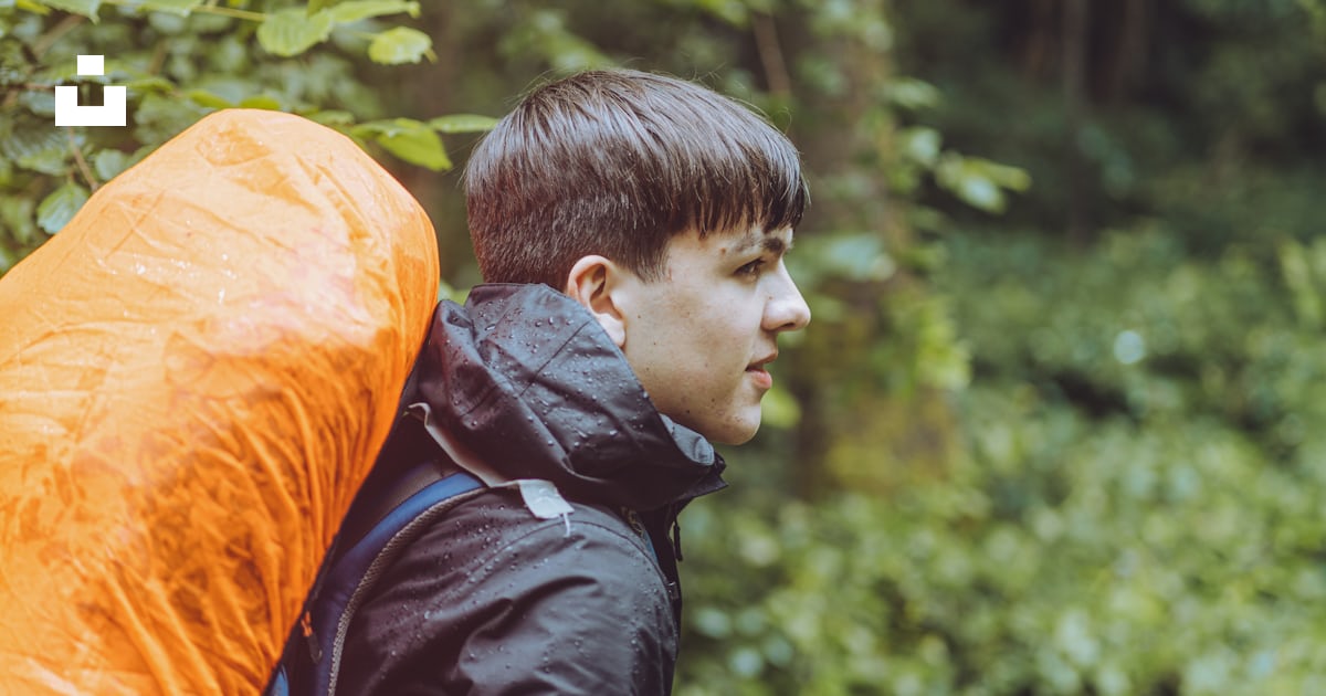 Foto Chico Con Chaqueta Negra Sentado En Un Textil Naranja Imagen