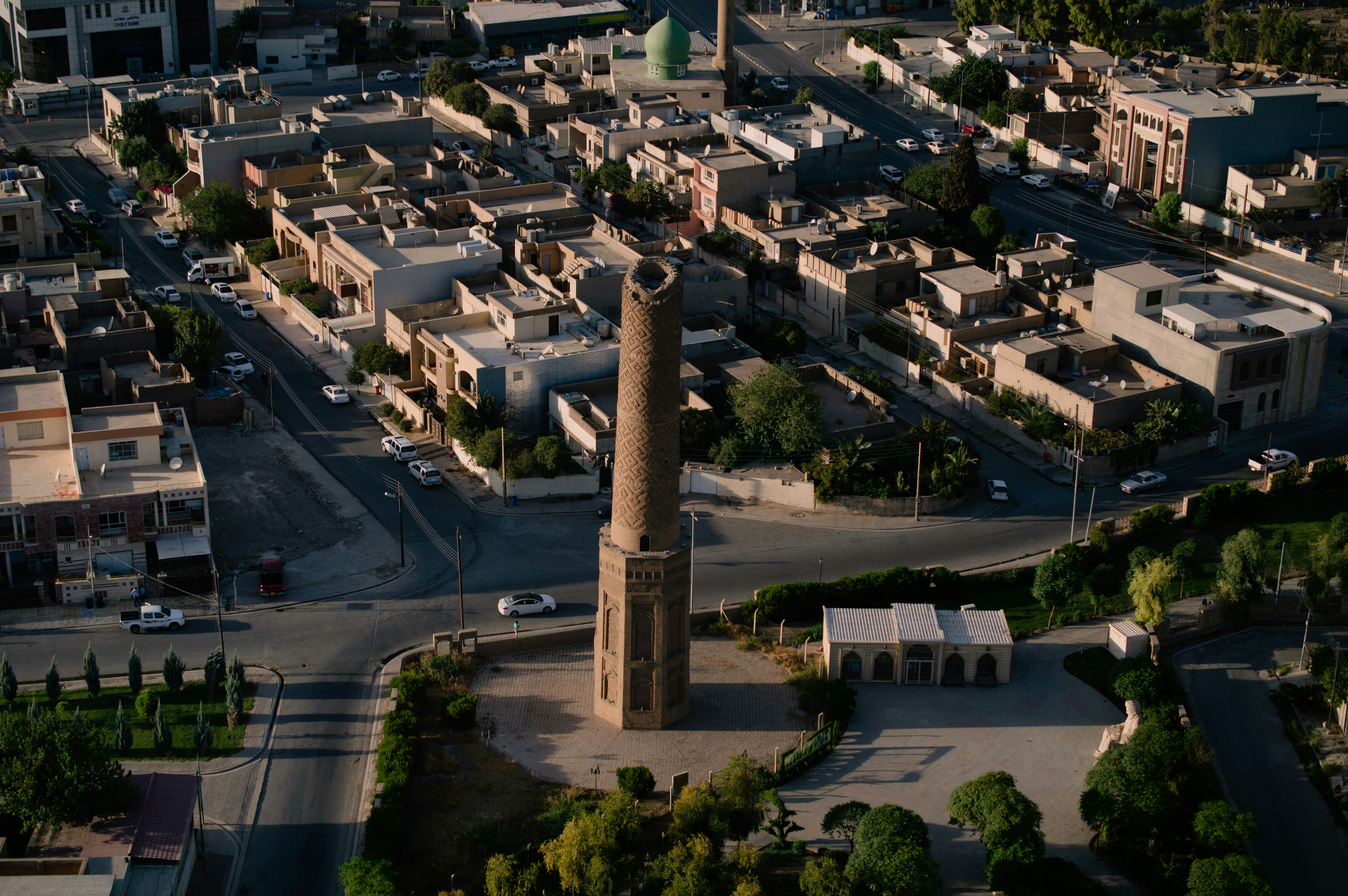 An aerial view of a historic tower surrounded by modern architecture and bustling streets, showcasing the blend of history and contemporary life.