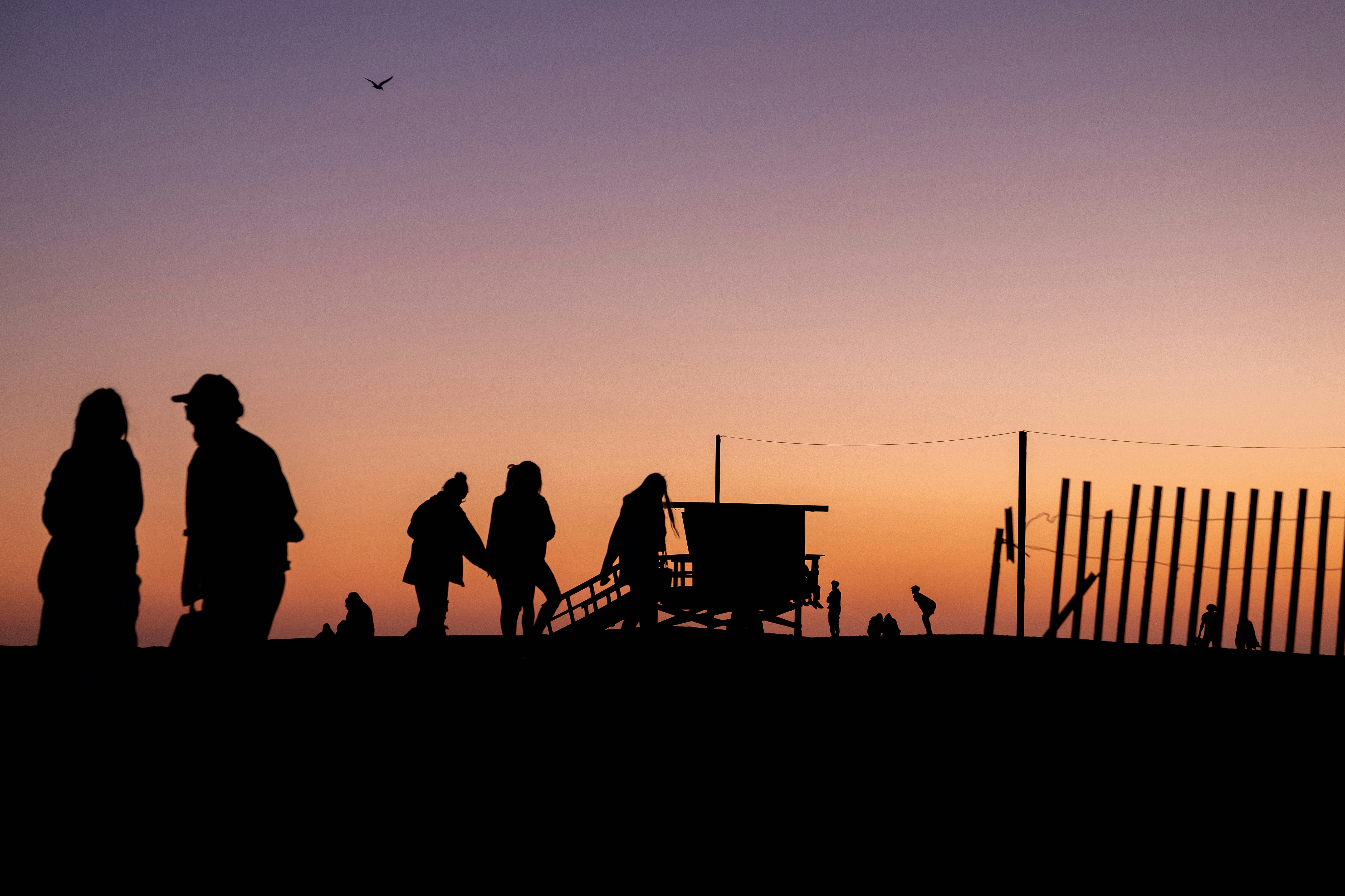 Lifeguard Tower at Dusk: Shadowed Figures on a Quiet Beach