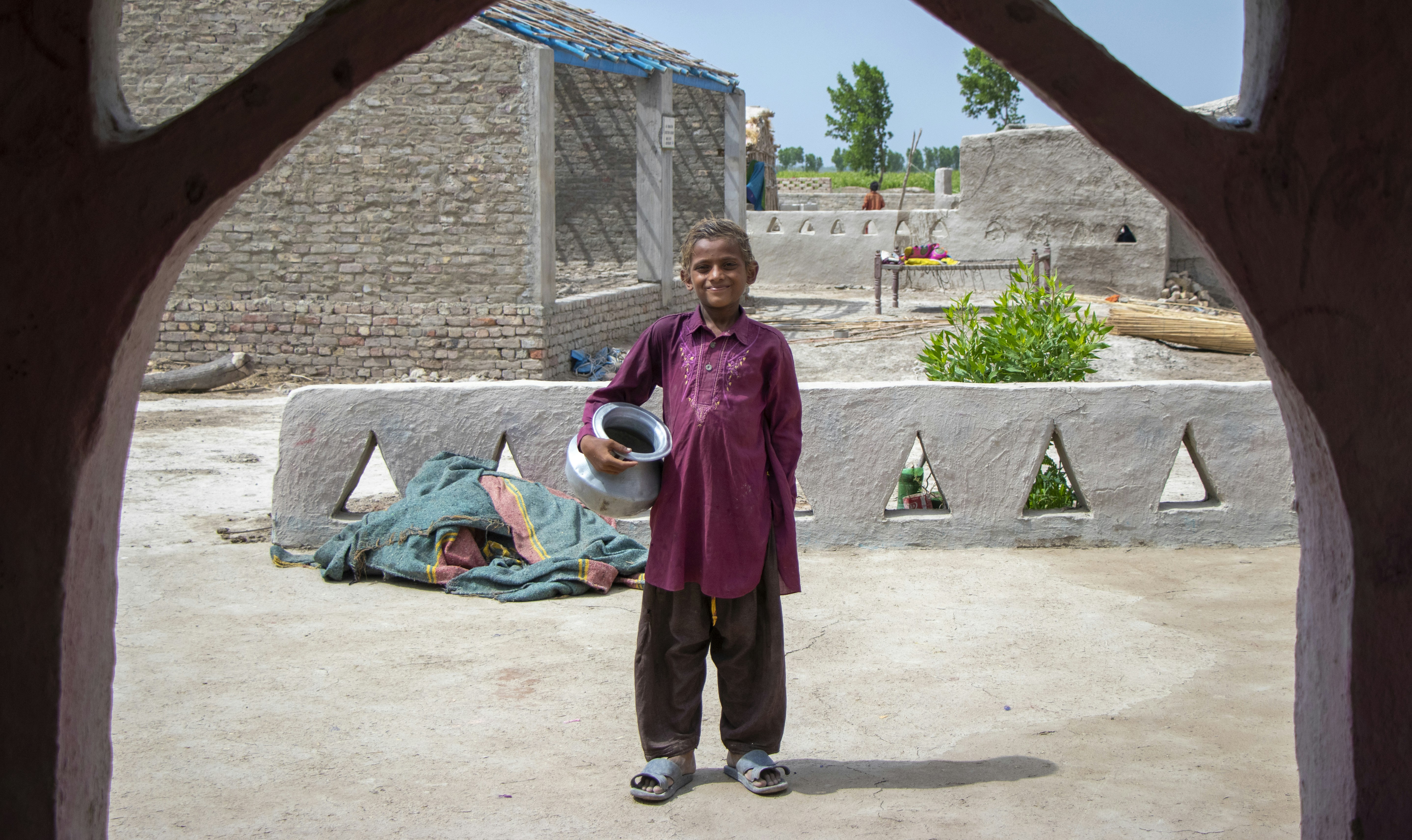 Archway Portrait: A Boy with Helmet in a Sunlit Courtyard