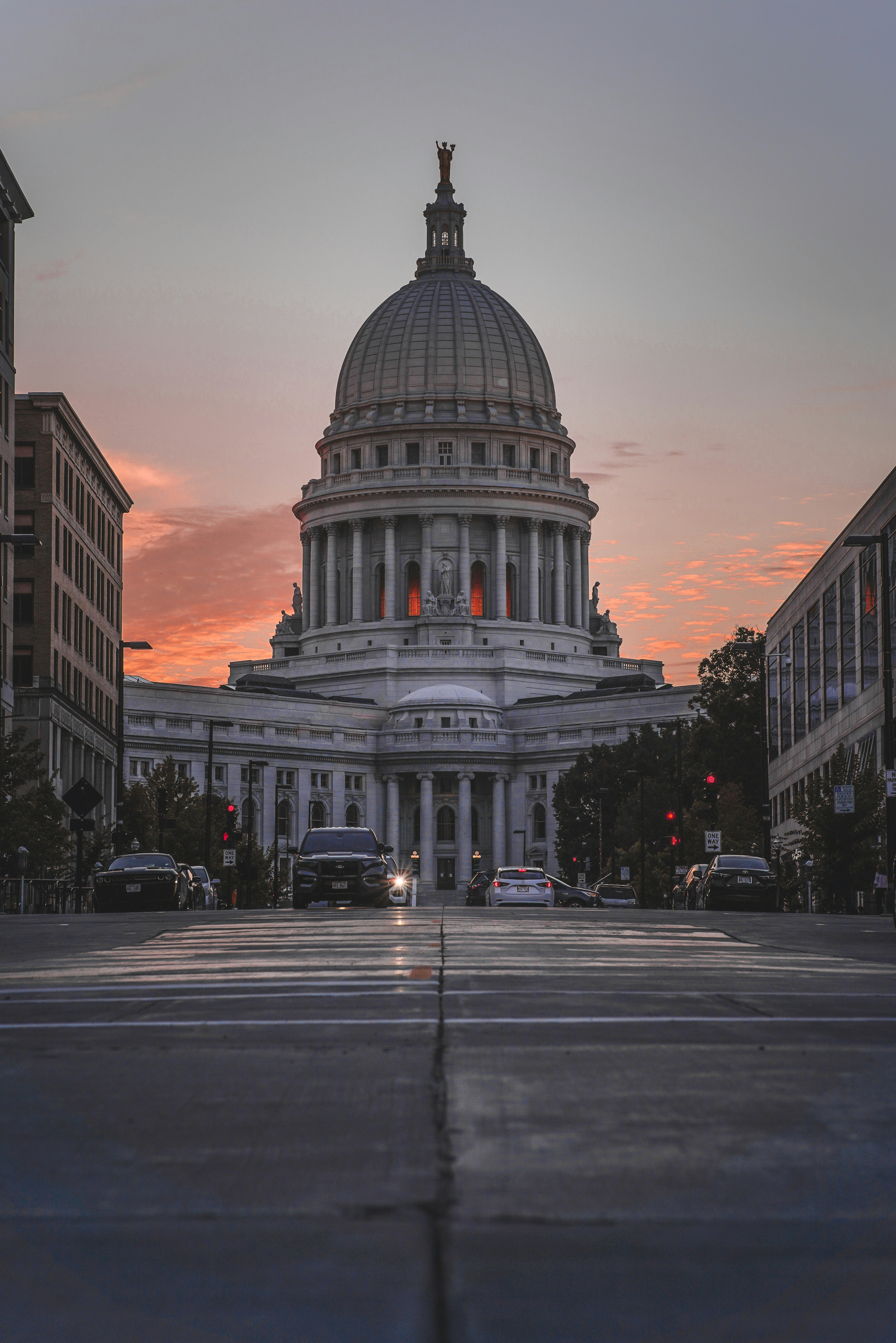 Majestic government building illuminated against a twilight sky, showcasing architectural grandeur and urban life. The scene captures the essence of civic pride and evening tranquility.