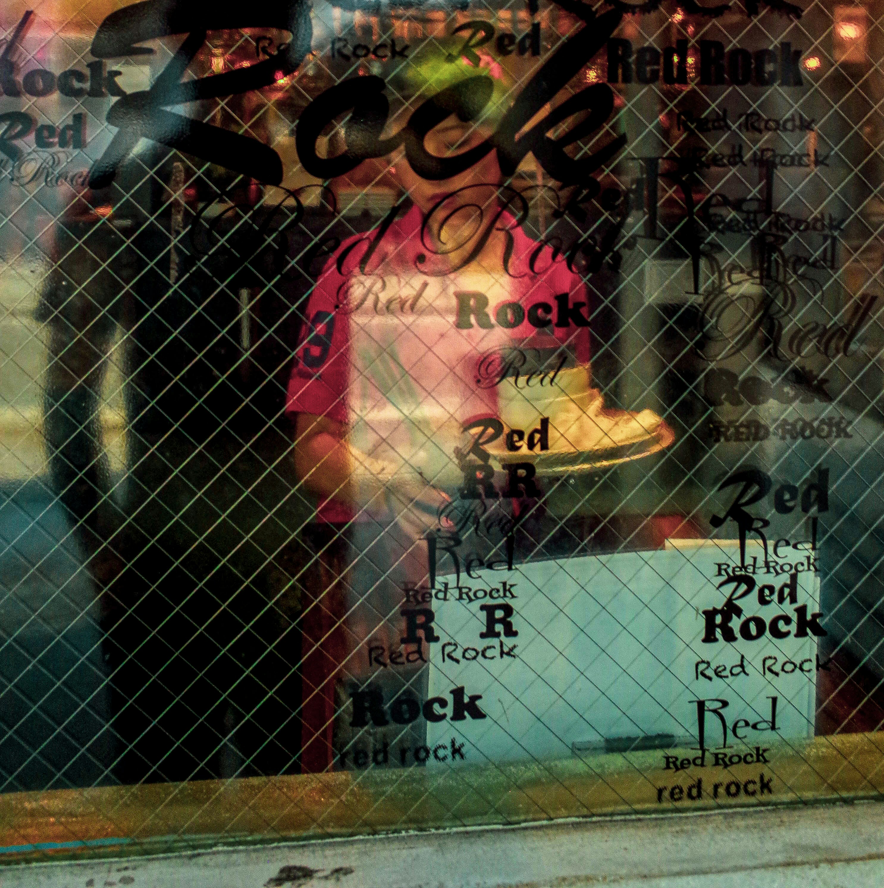 Red Rock Reflections: Neon Shoes Through a Graffitied Window