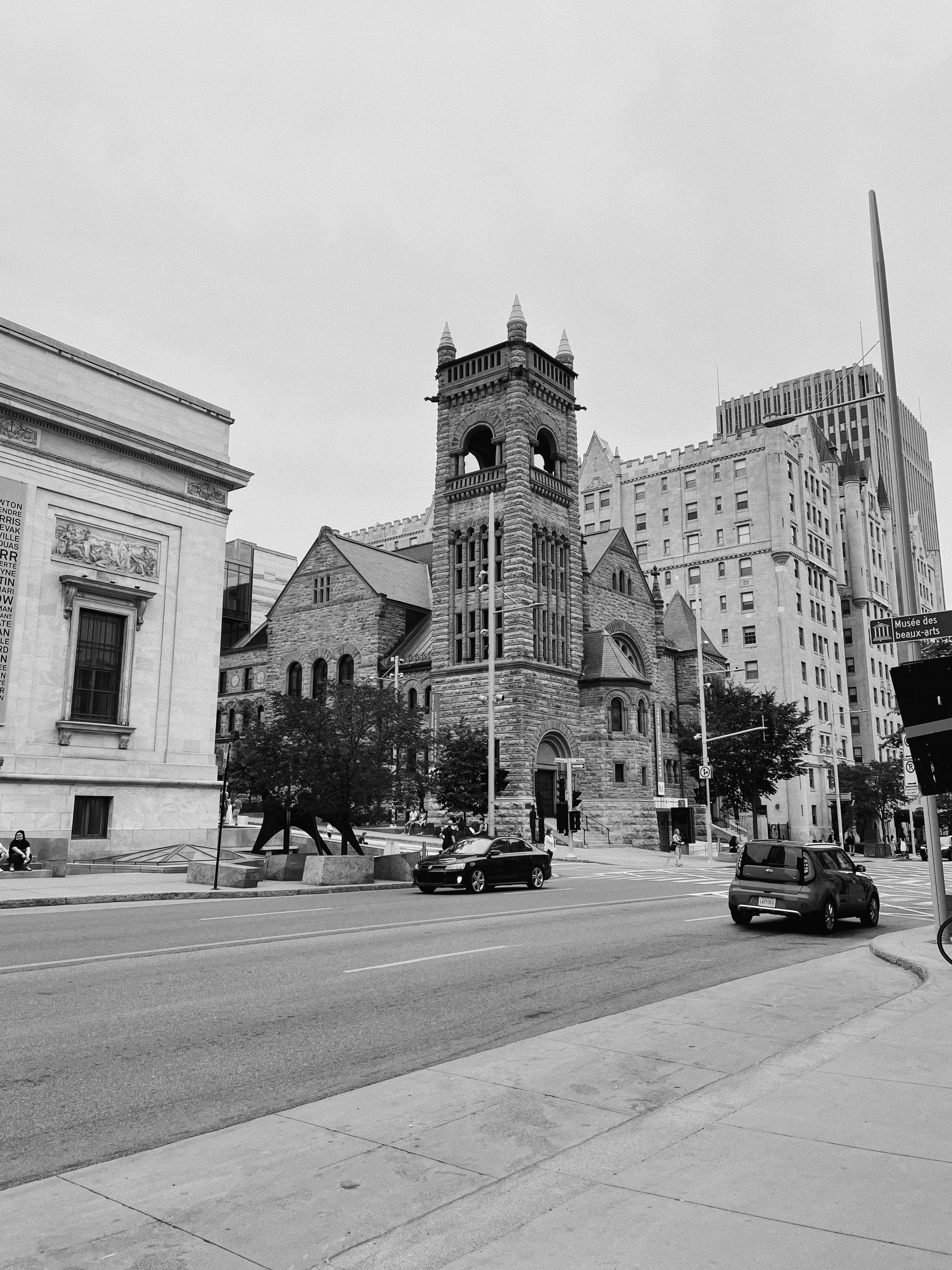 grayscale photo of cars parked near building