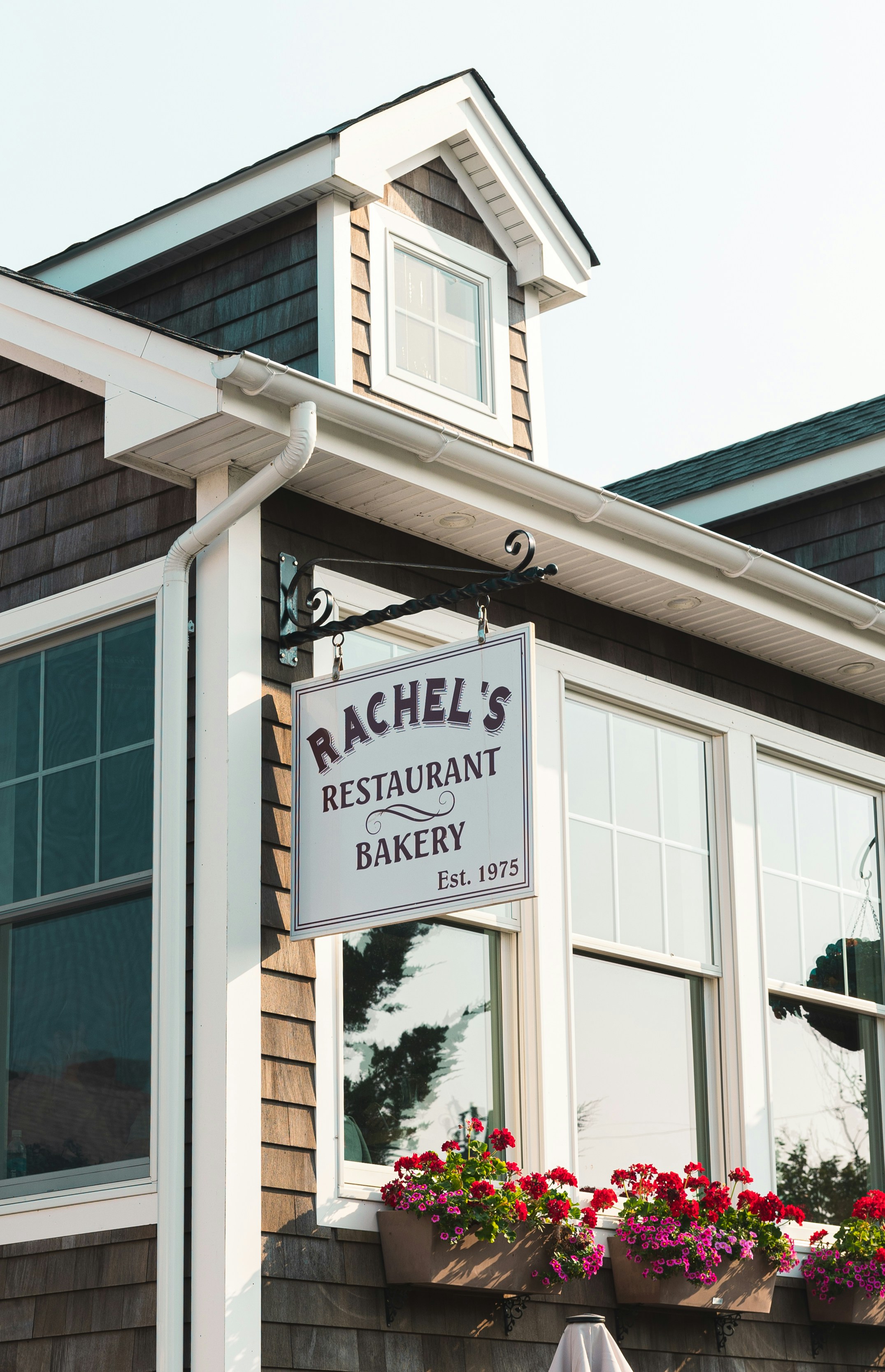Sunlit Signboard Over a Flower-Draped Façade: Rachel's Restaurant & Bakery
