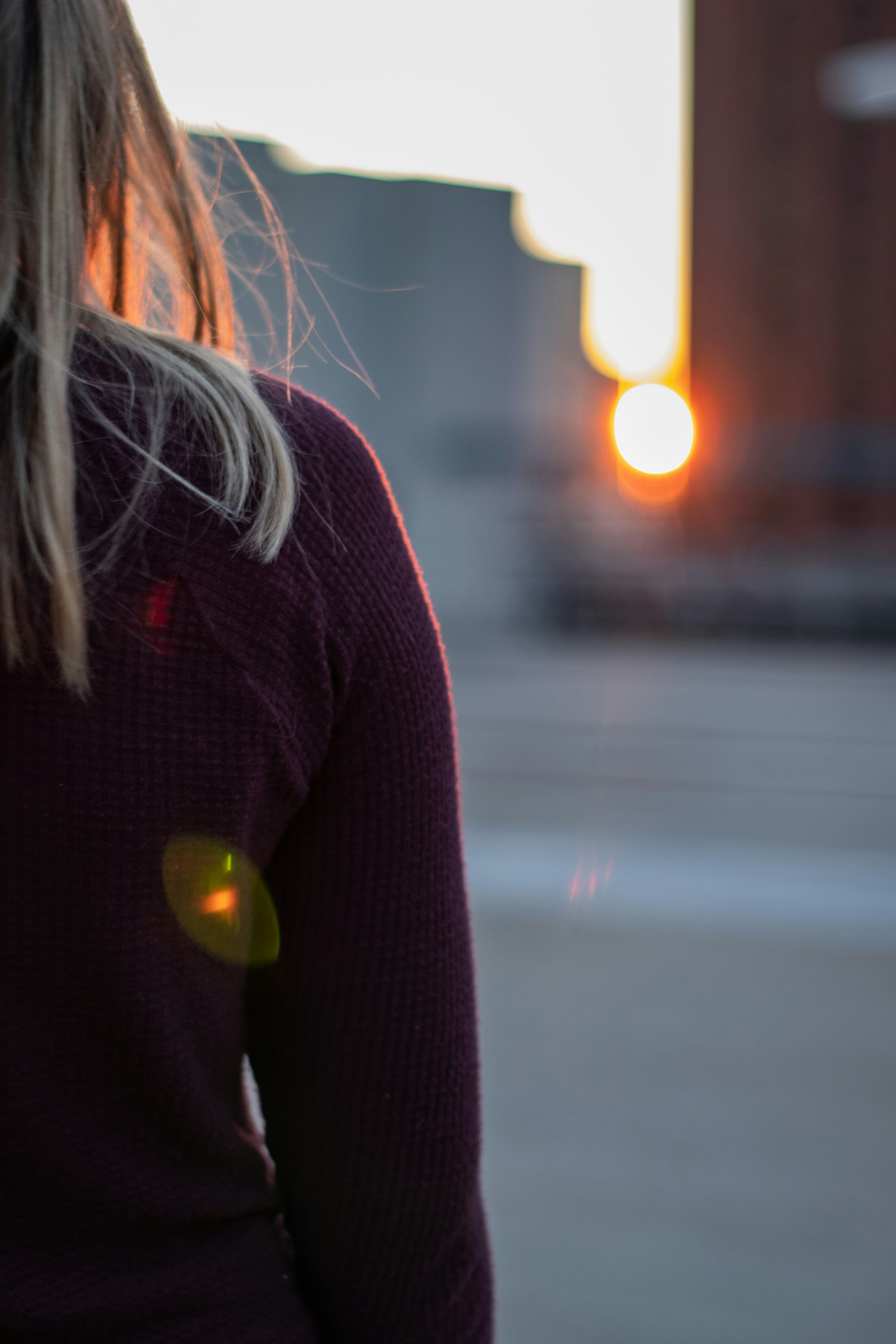 Dusk Portrait: Burgundy Knit Against a City Sunset