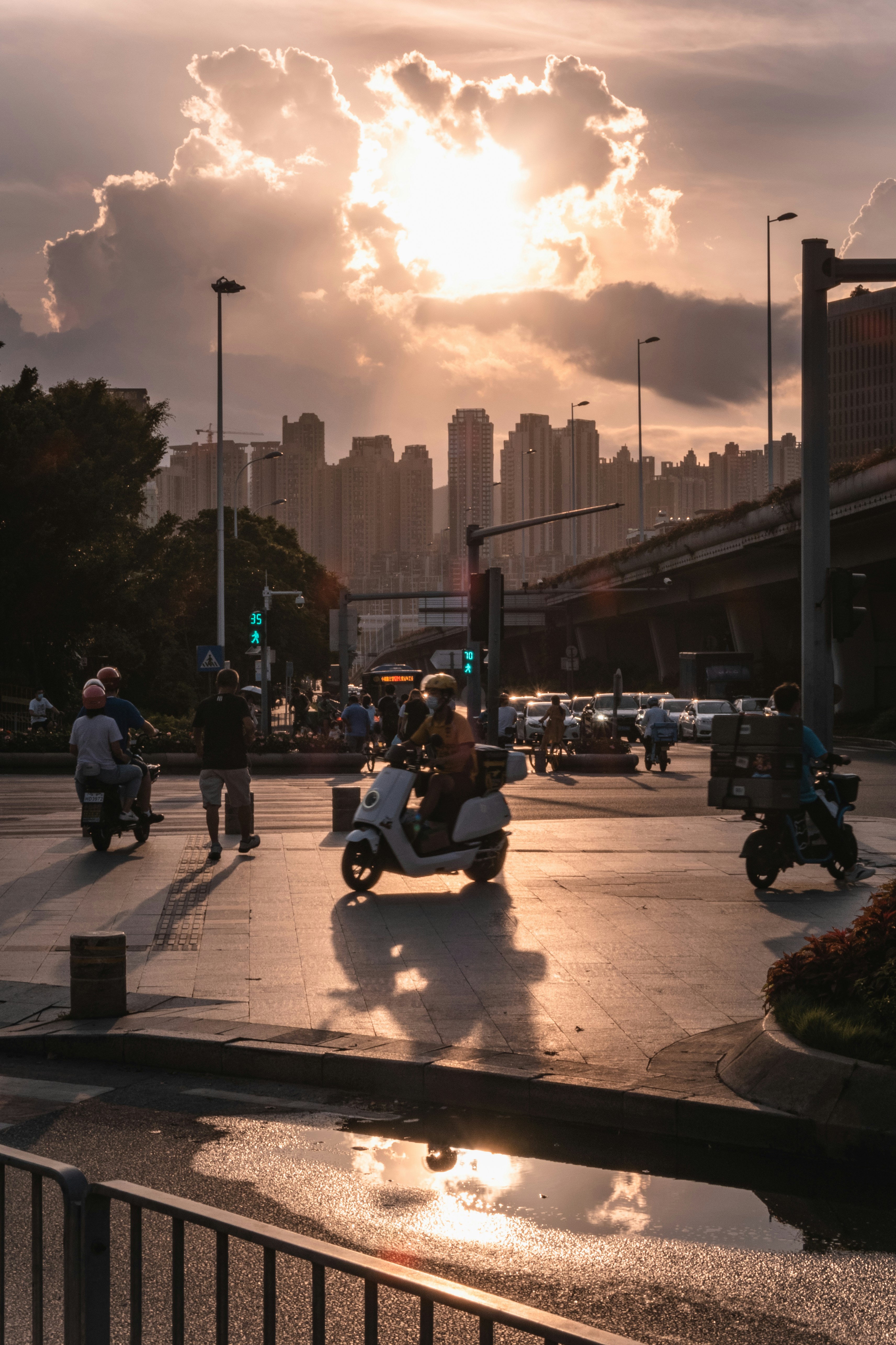 Sunlit Crossroads: Dusk Riders Thread Through a City Horizon