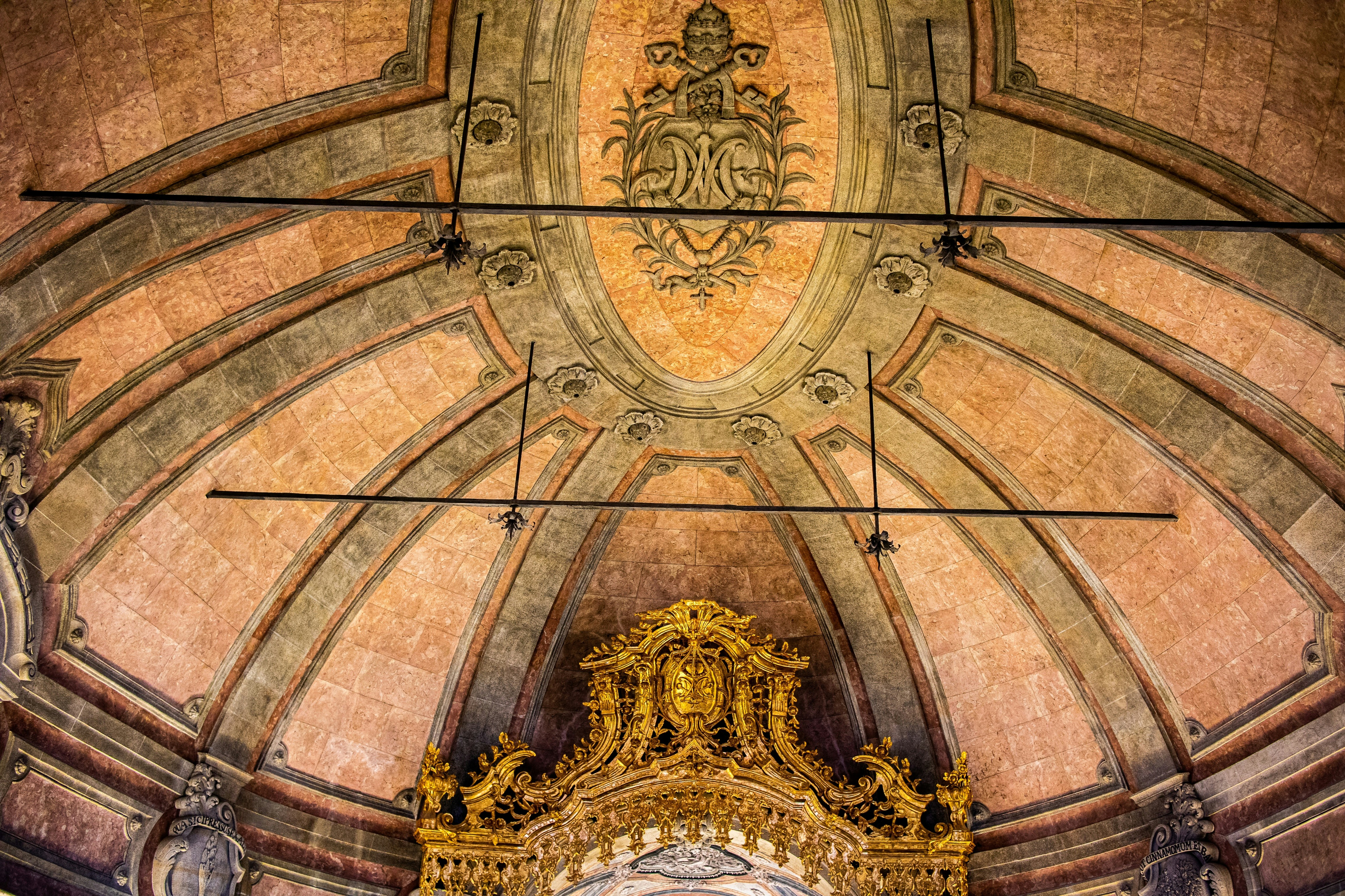 Intricately designed dome ceiling with gold accents and a central emblem.
