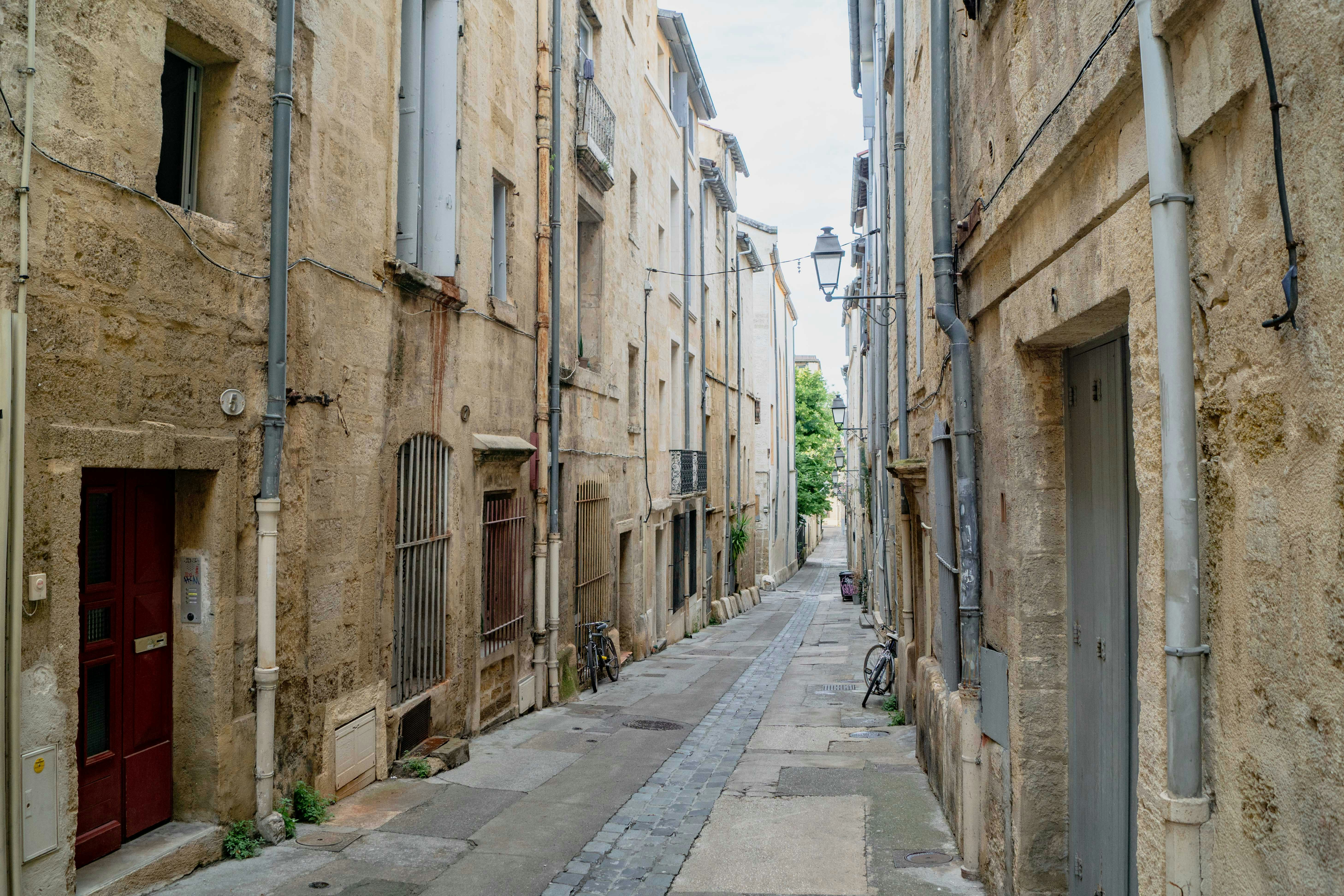 Narrow cobblestone alley framed by weathered stone buildings, inviting exploration through its historic charm.