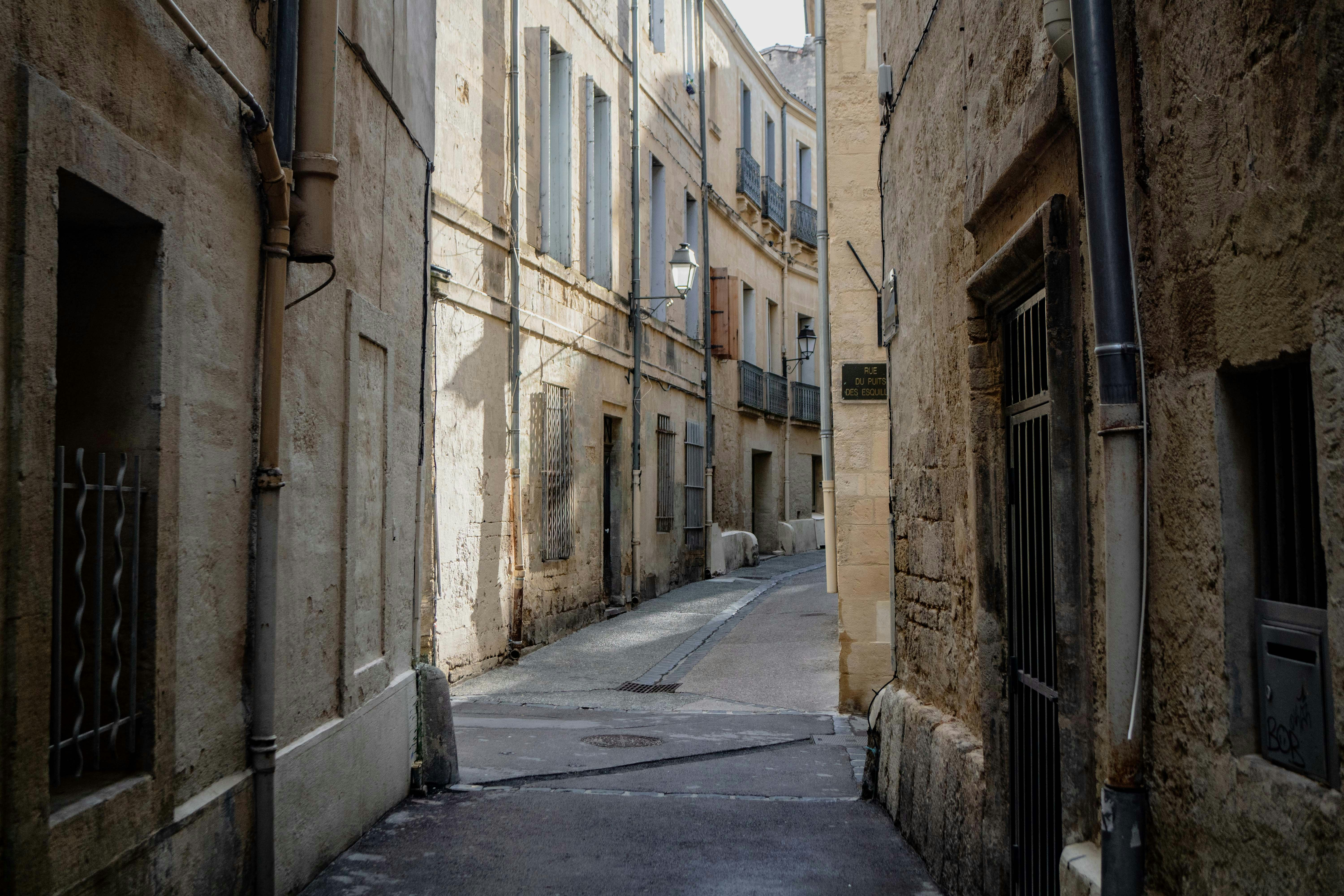 empty street between concrete buildings during daytime