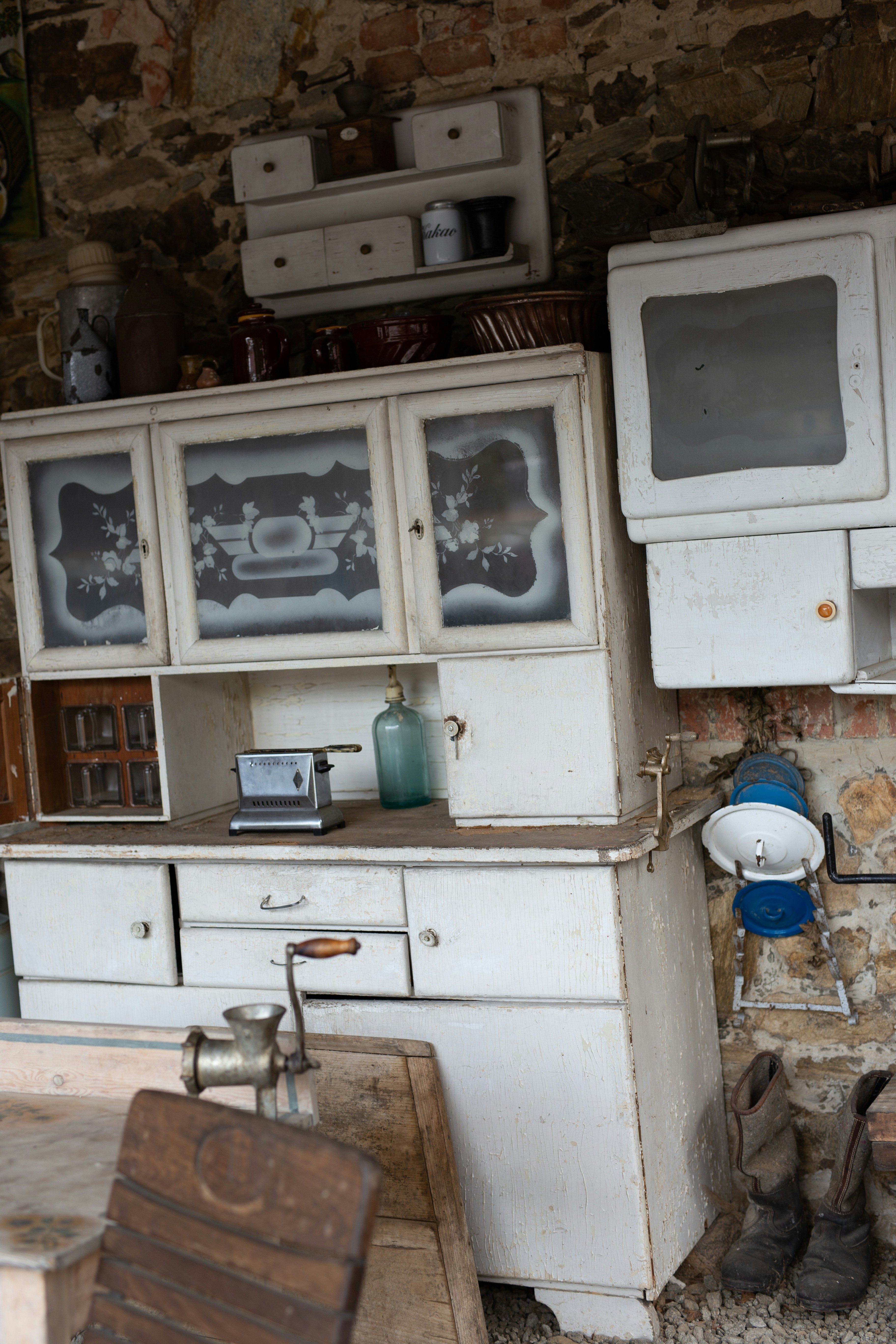 Rustic Kitchenette: A Timeworn Cabinet Nestled Against Stone Walls