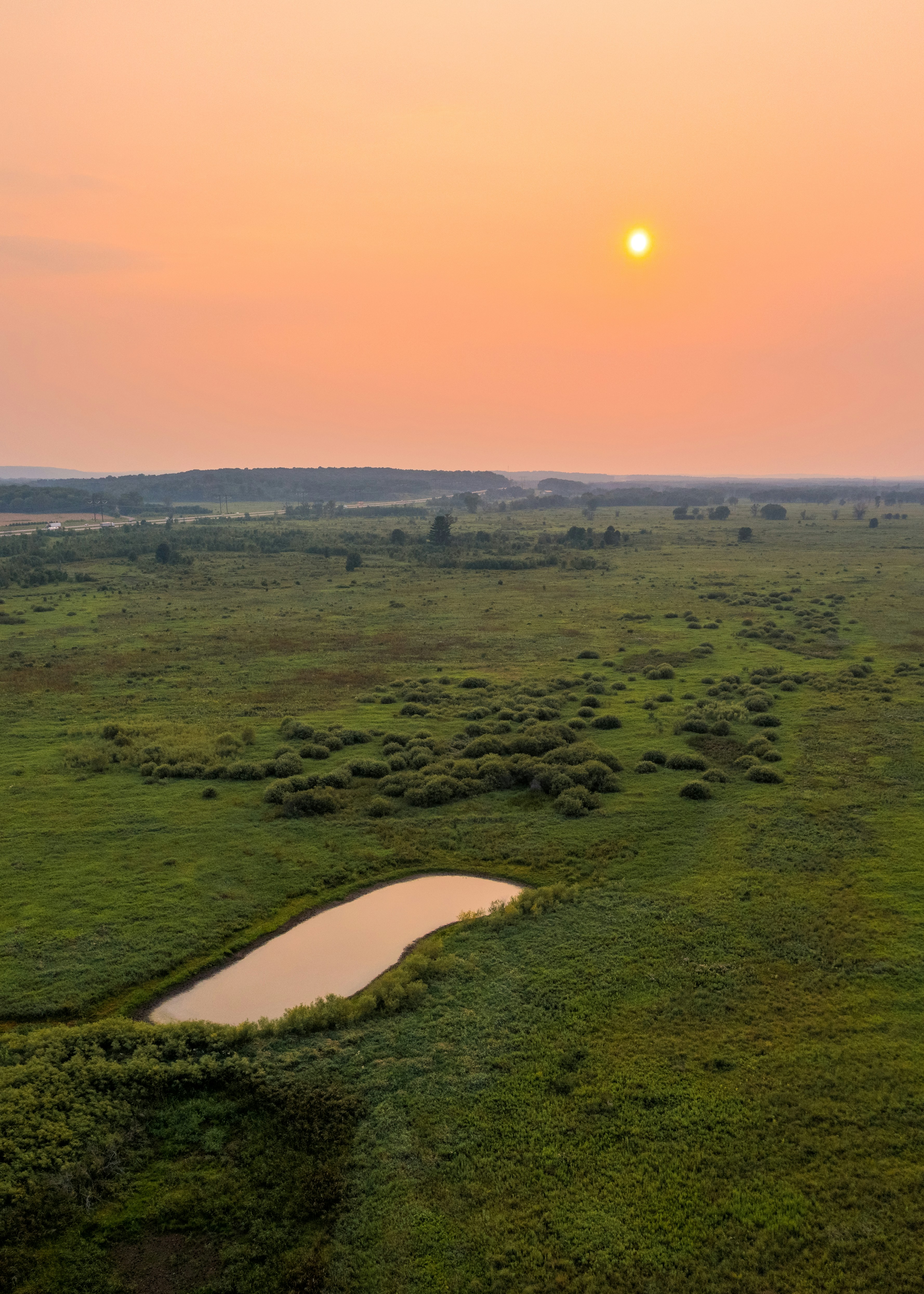Peach-Sky Prairie: Sunset Over a Quiet Pond
