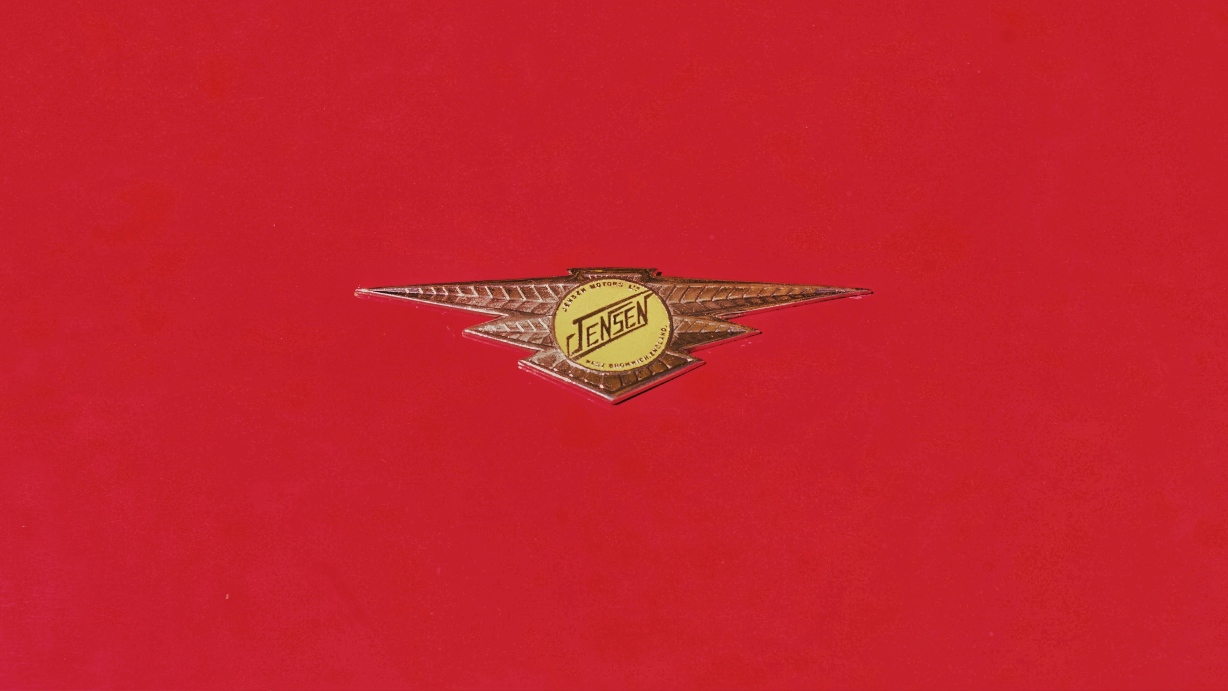 Scarlet Crest: Jensen Winged Logo on a Red Field