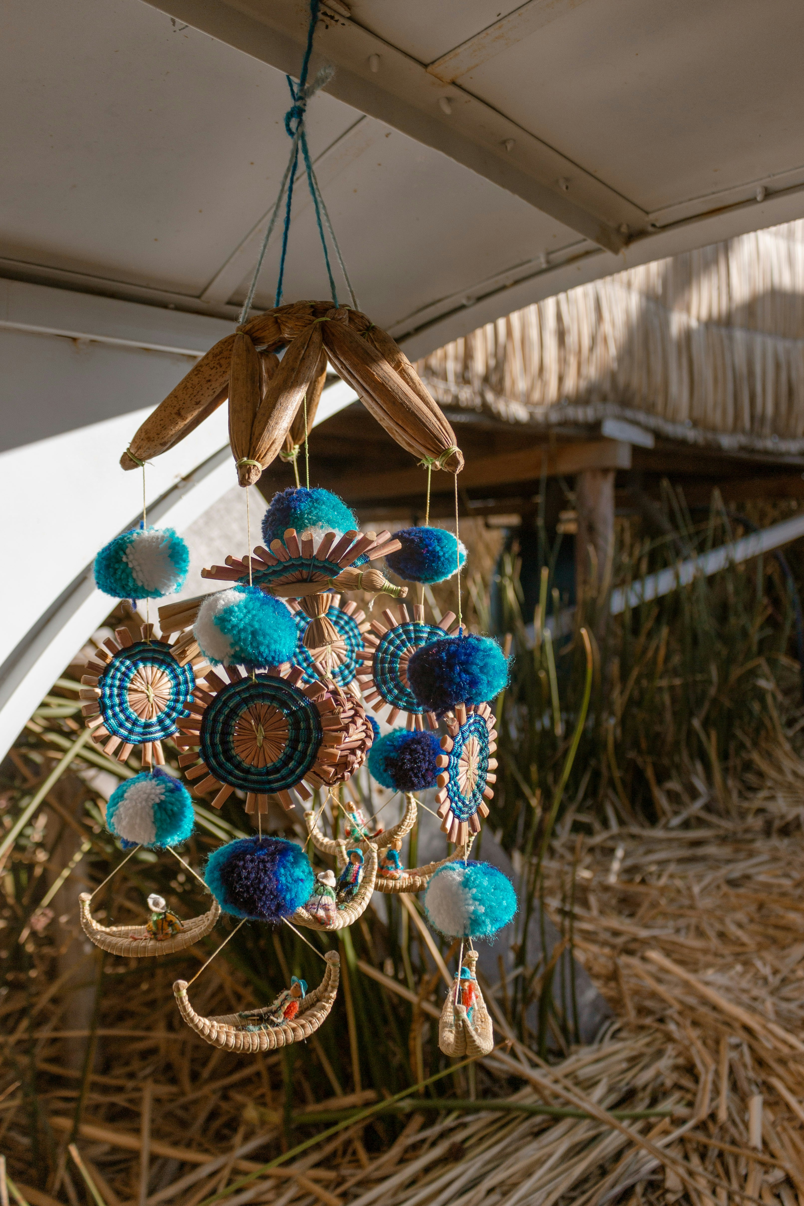 Azure Pom-Pom Ornaments and Handwoven Medallions Hanging in Sunlit Shade