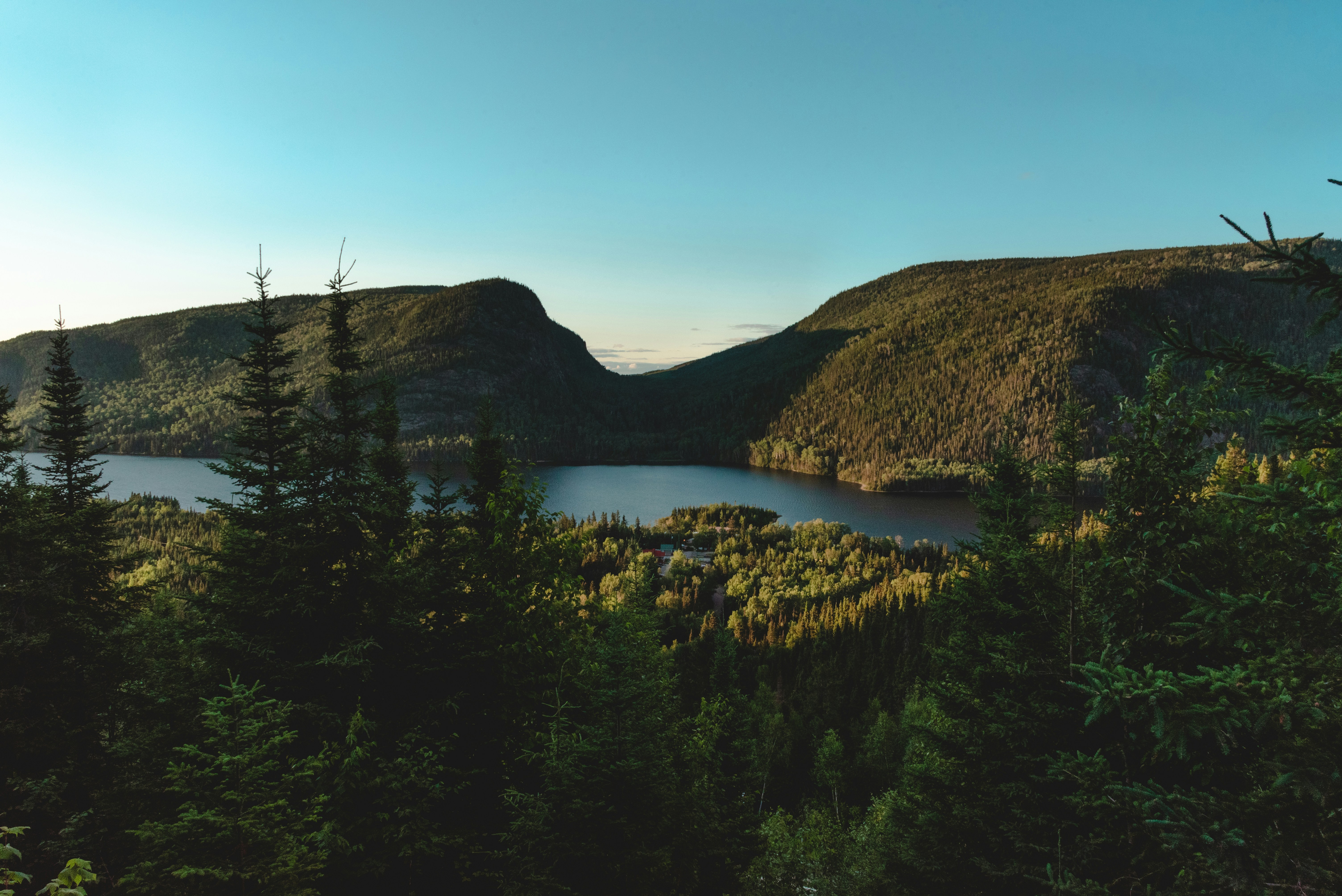 Golden Hour Framing: Forested Ridges Embrace a Tranquil Alpine Lake