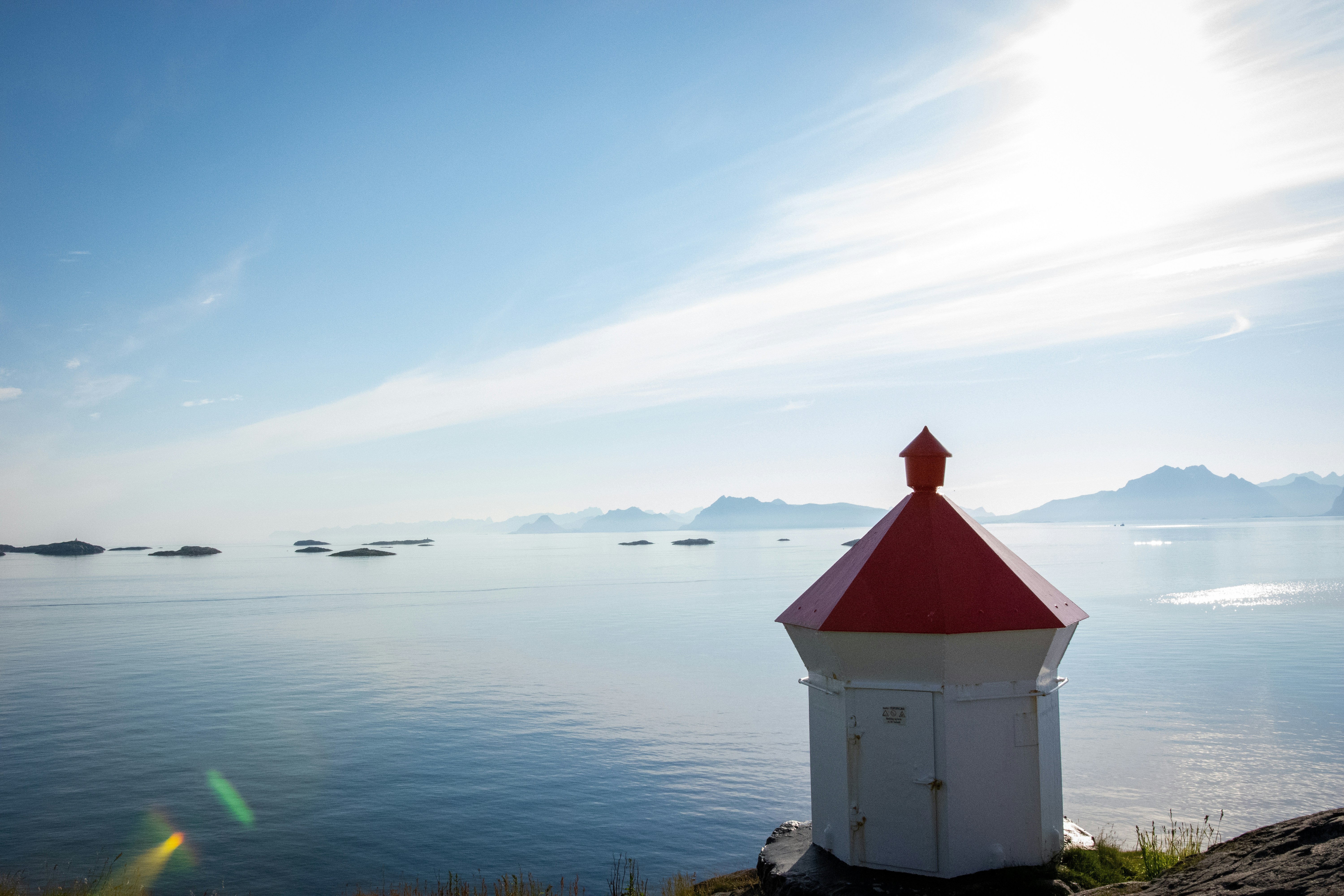 Red-roofed beacon by the tranquil fjord