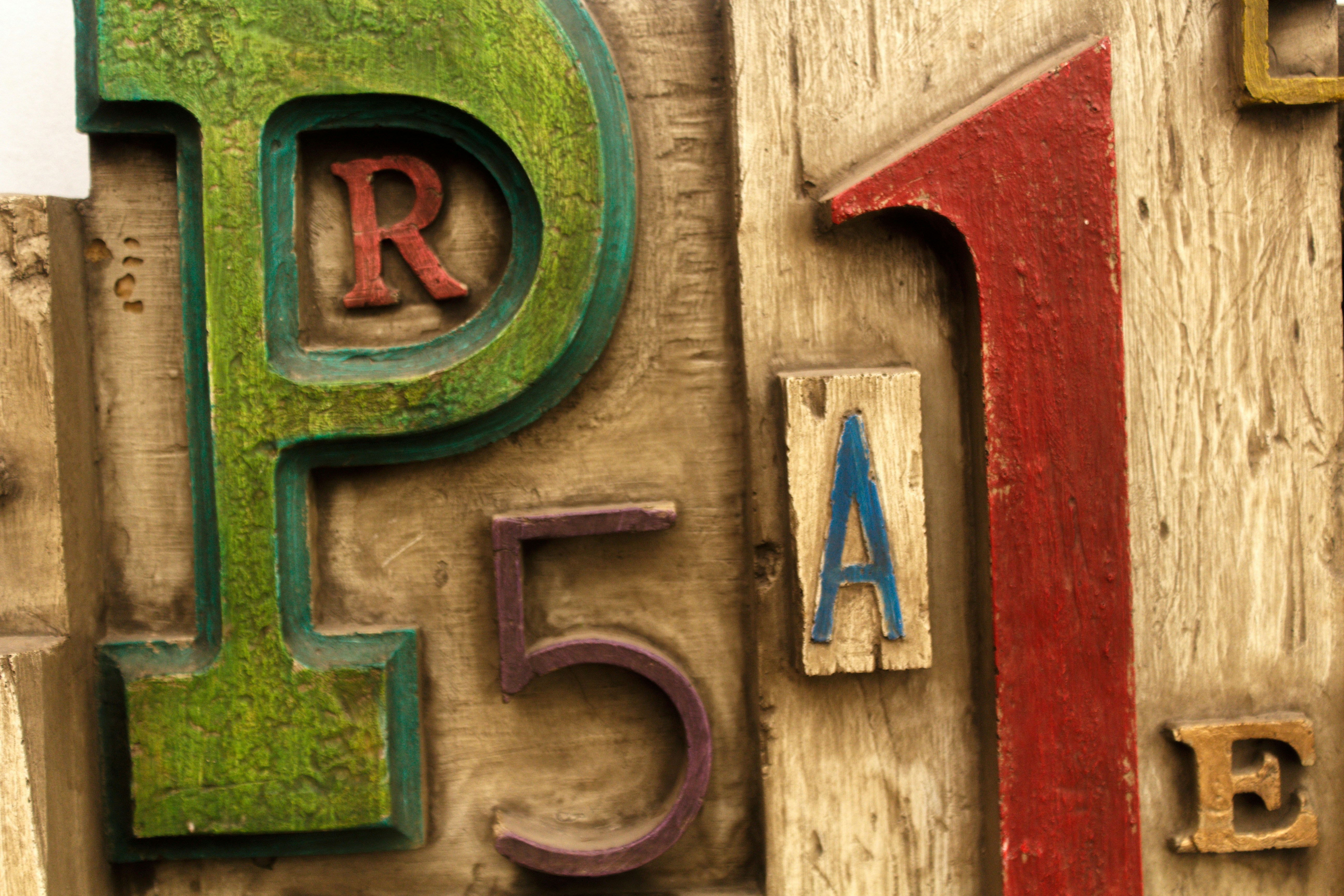 Moss-green P Frames a Red R in a Rustic Wooden Letter Montage