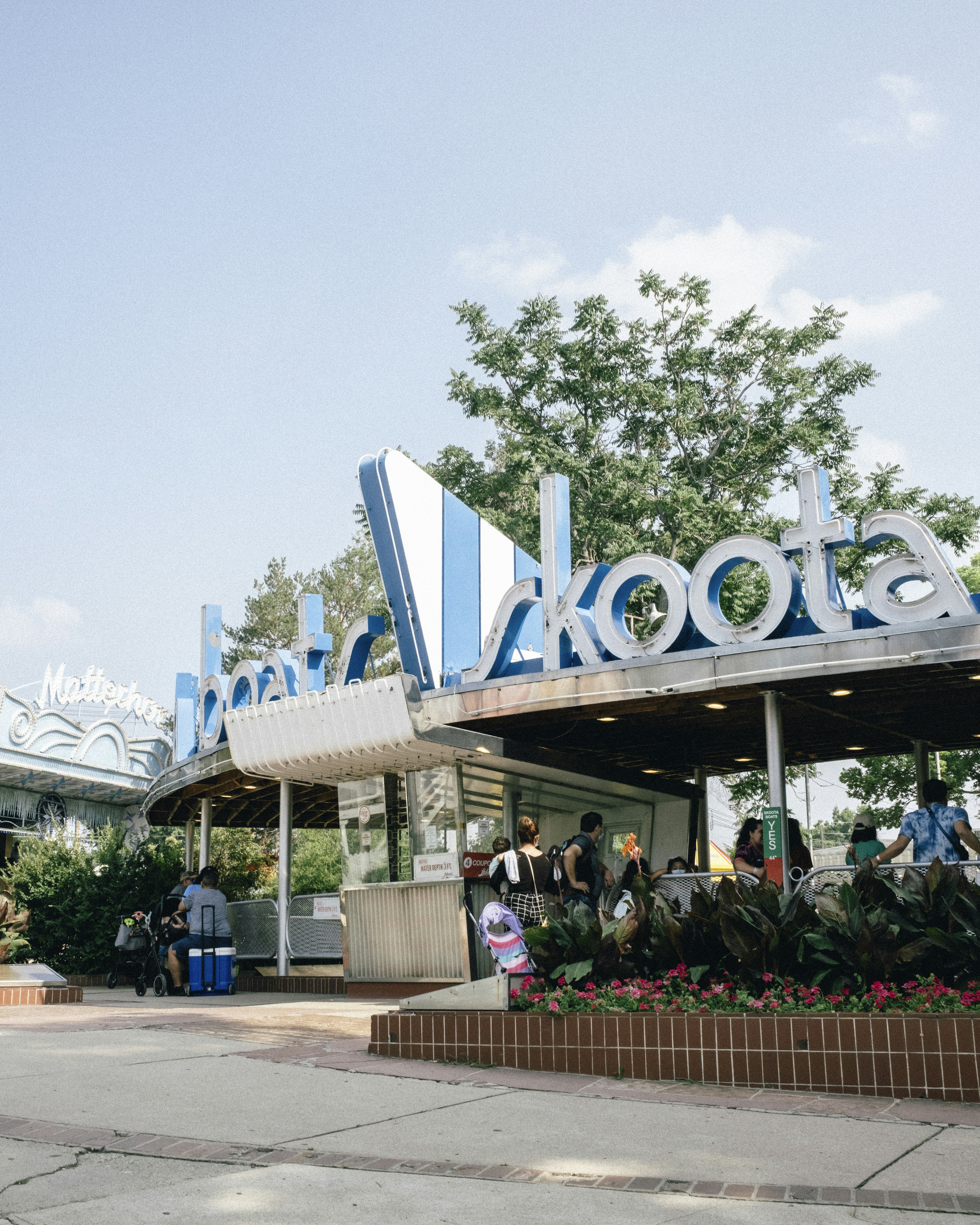 Azure Gateway: A Sunlit Park Entrance Framed by Blue Signage