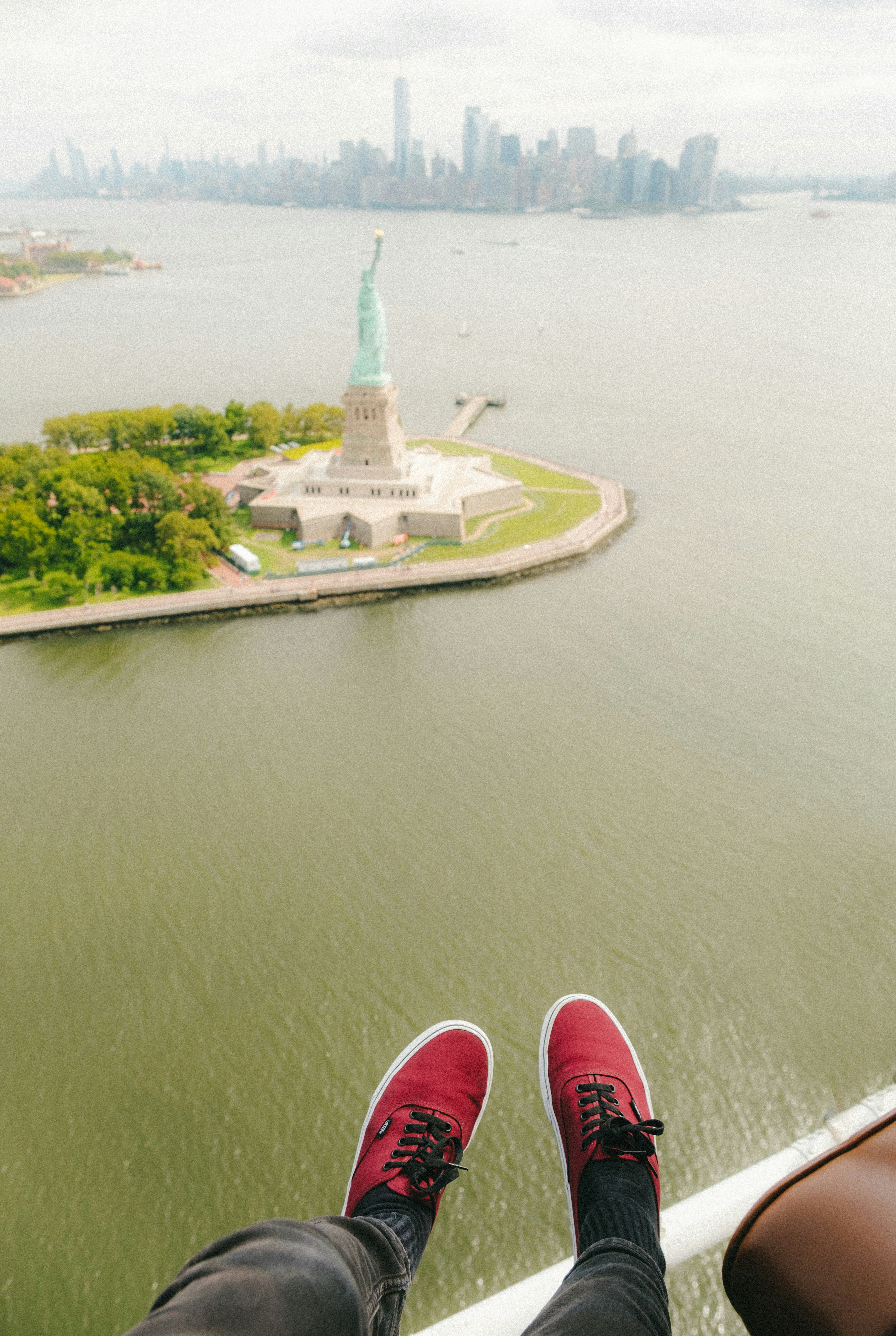 Red Sneakers Over Liberty Island: An Aerial Gaze Toward NYC Harbor