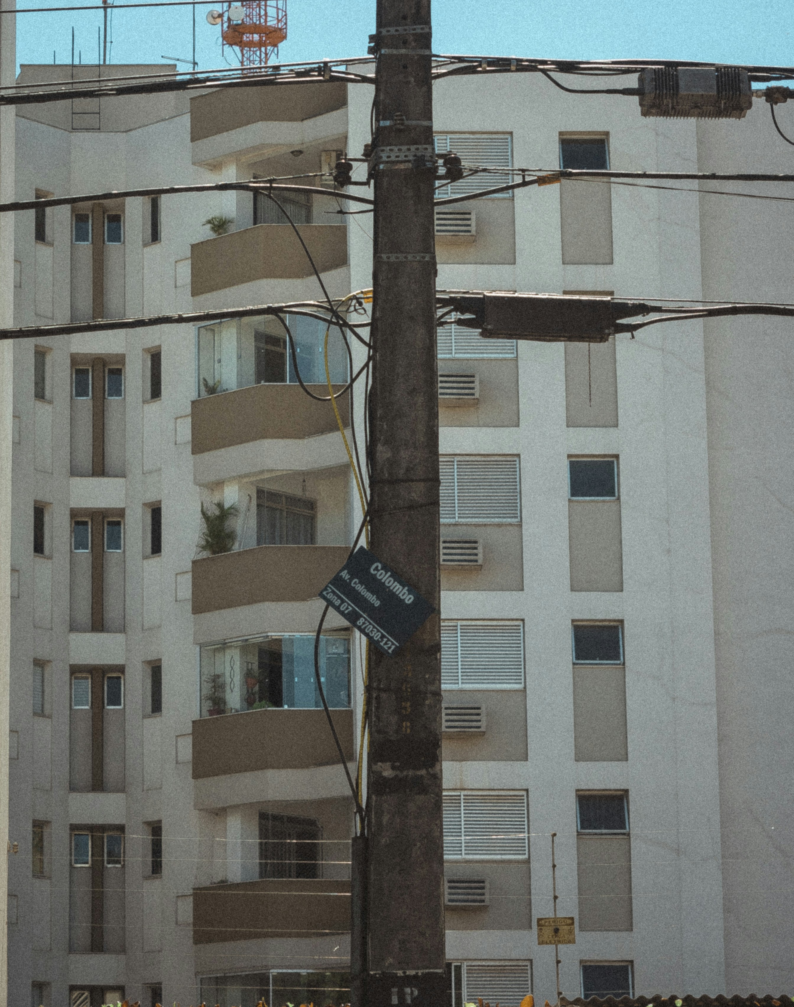 
power pole with sign and building in the background