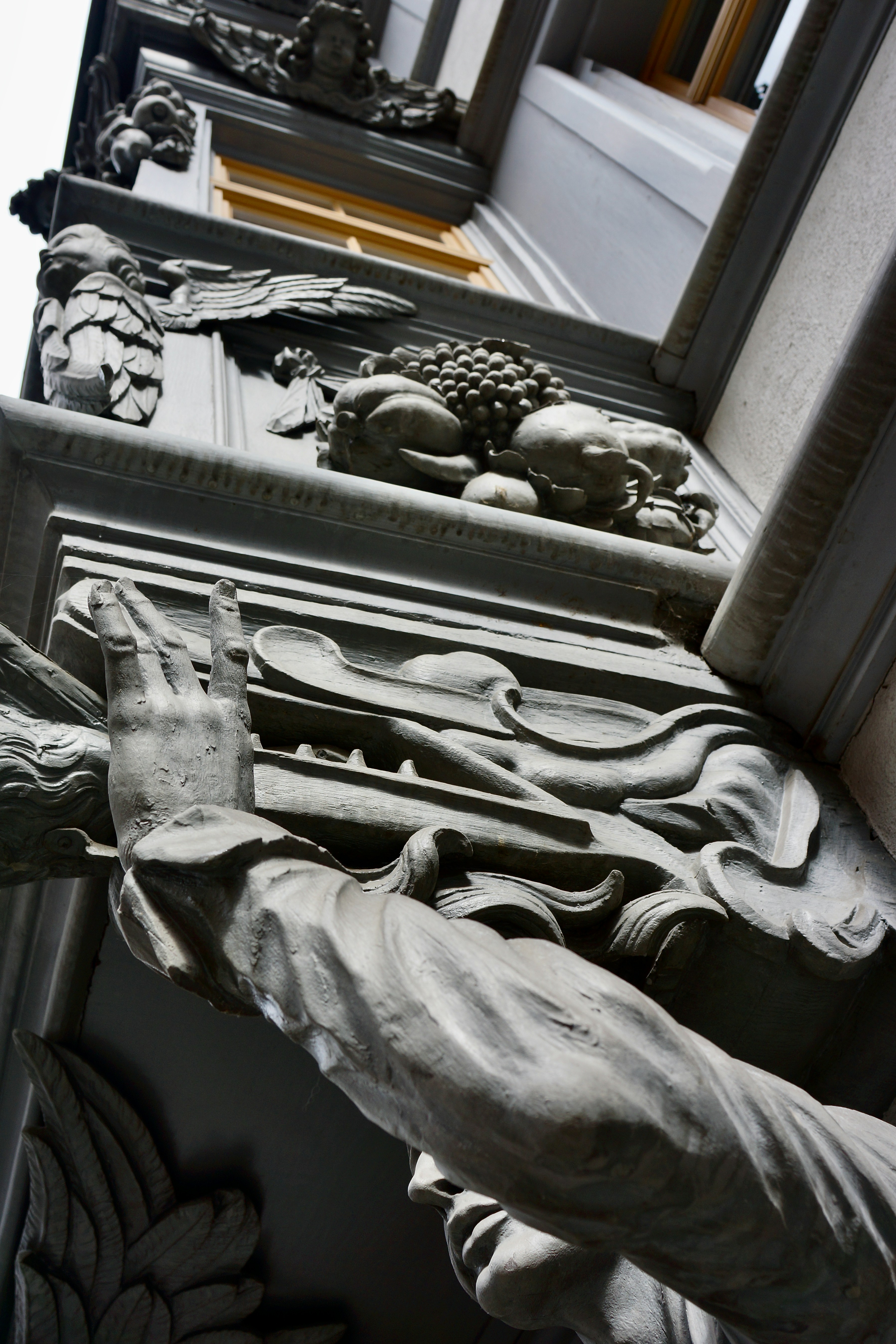 Winged reliefs and carved guardian figures along a monumental stone facade