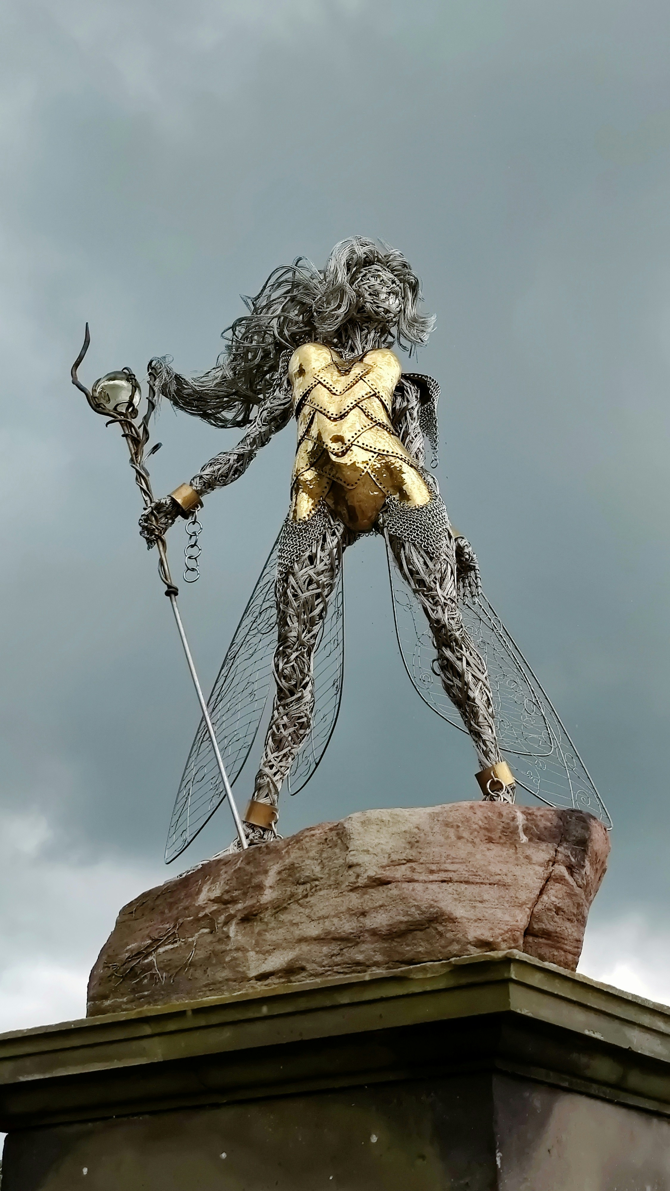 Iron Monarch Ascends: A Winged Guardian Statue on a Stormy Pedestal
