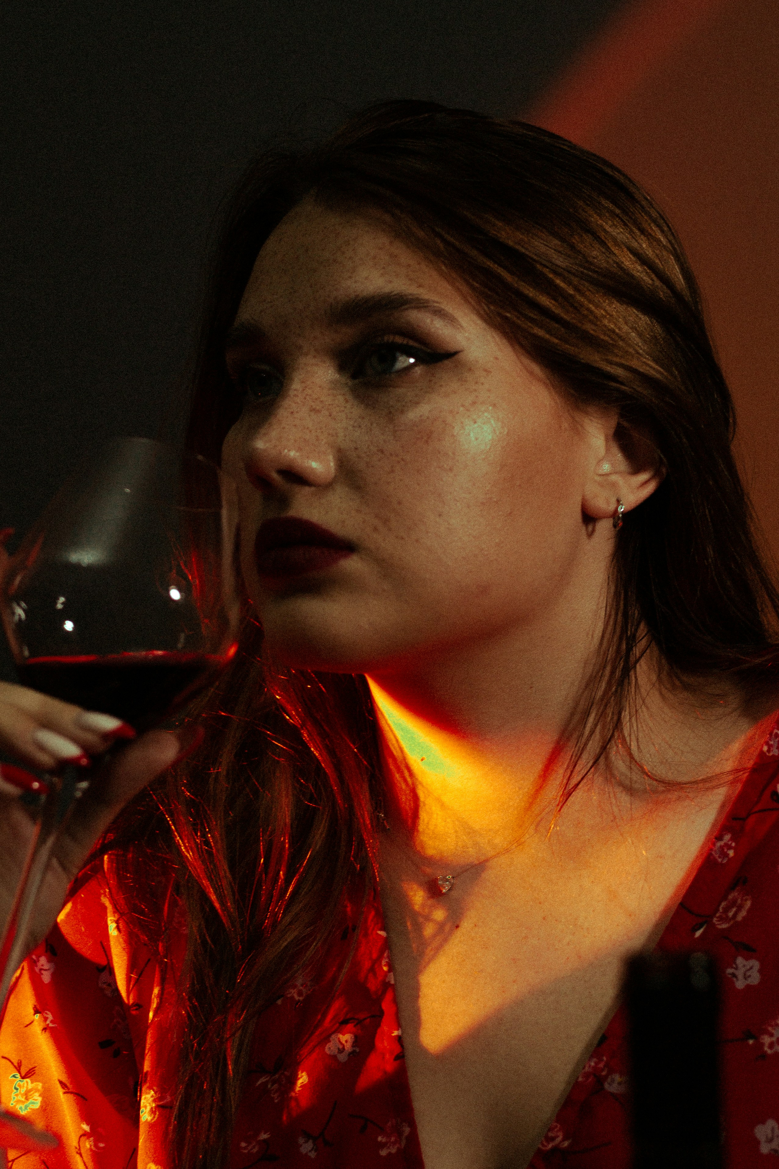 Crimson Backlight Portrait: Quiet Confidence with a Wine Glass