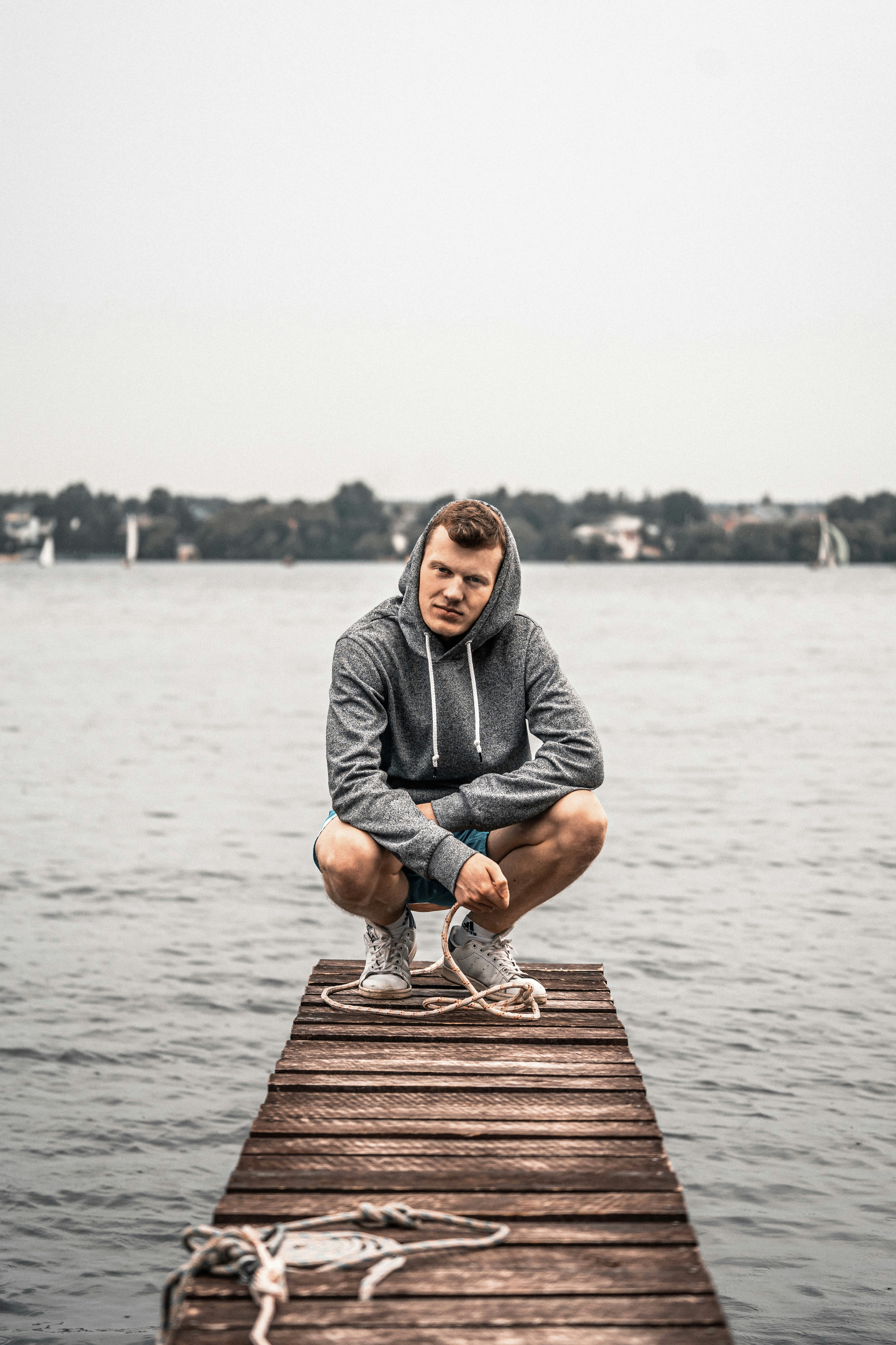 a man sitting on a dock tying his shoes