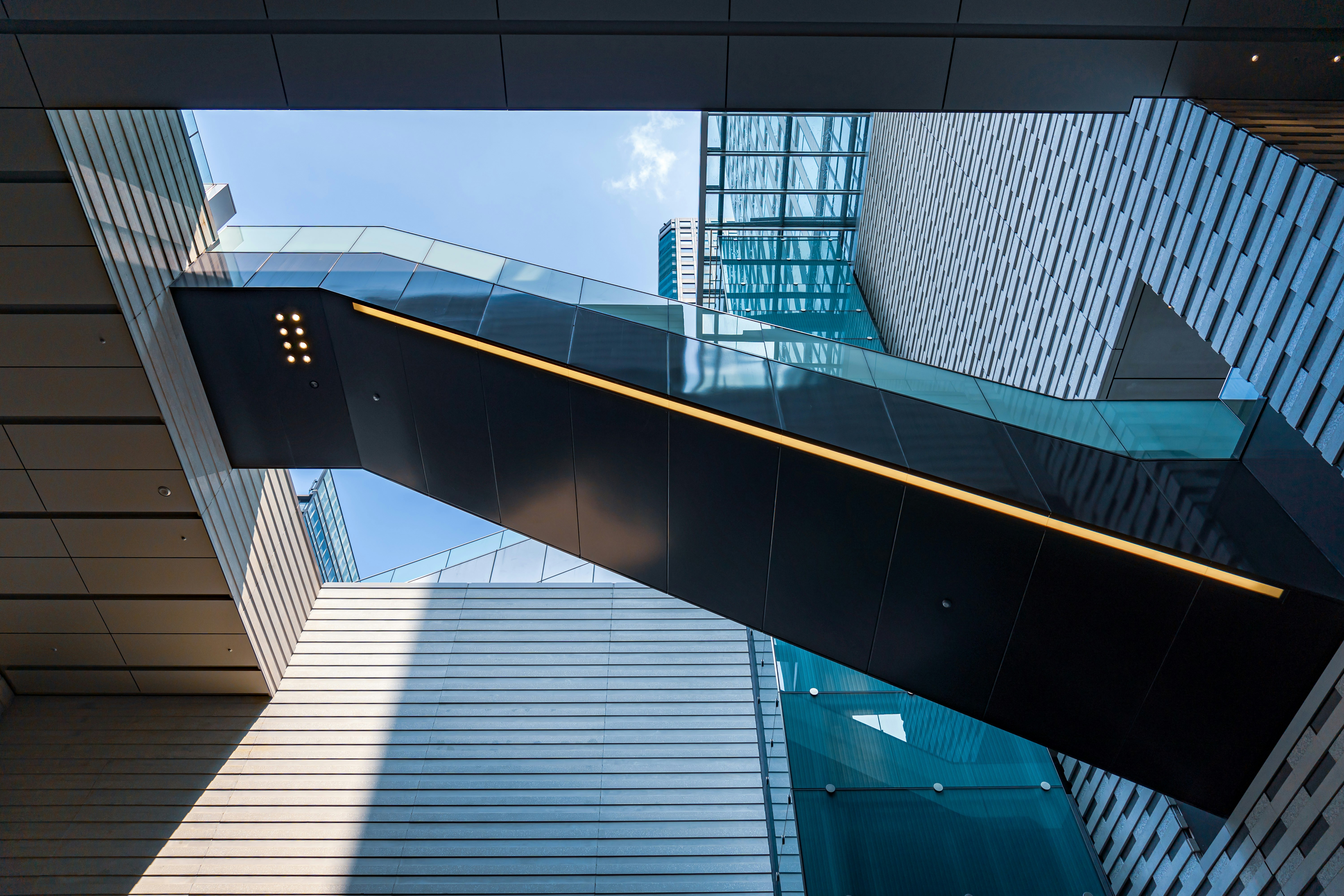 Modern architectural design featuring sleek lines and glass elements, showcasing a striking interplay of light and shadow.