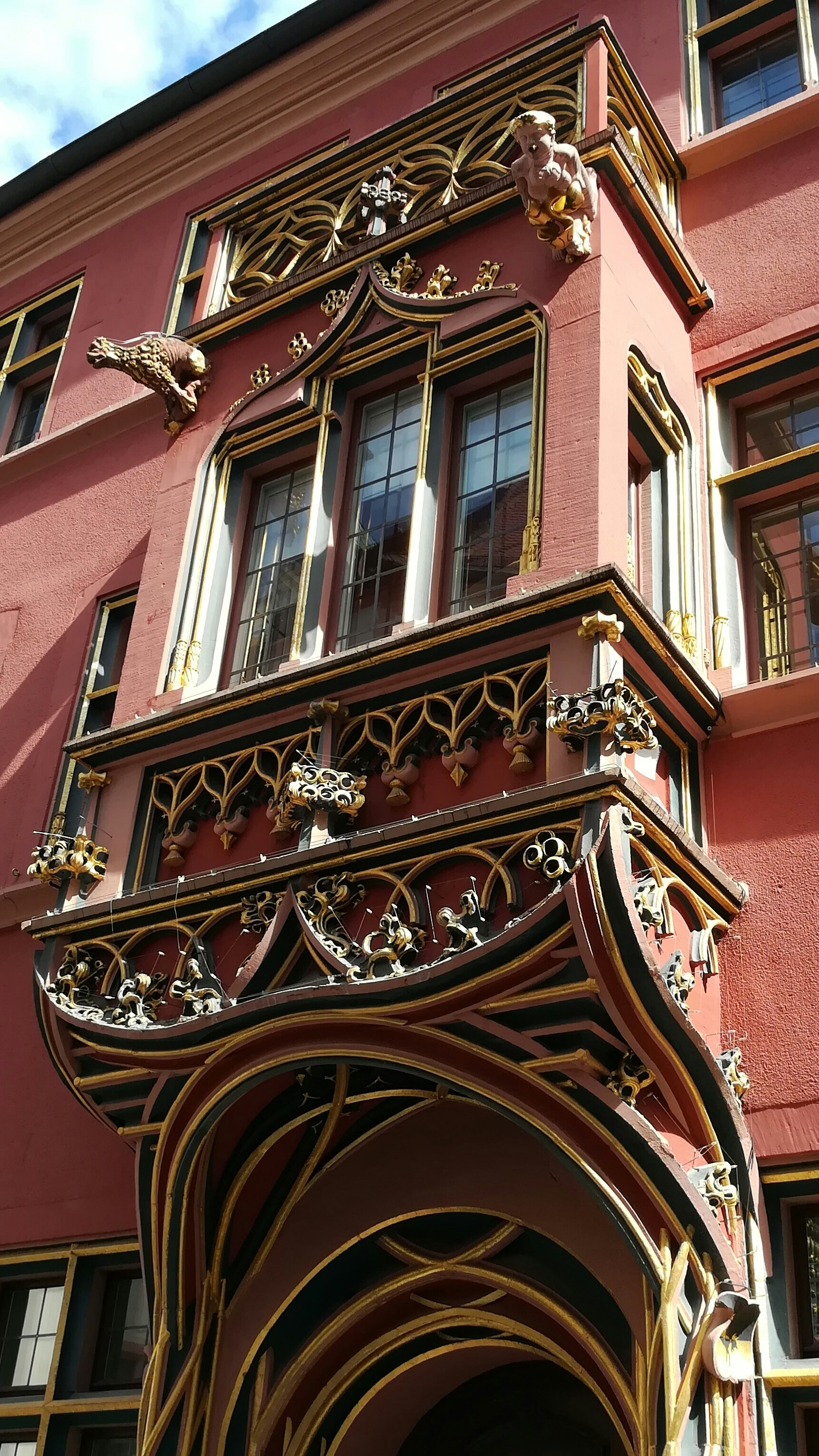 Dragon-Guarded Facade: Gold-Trimmed Archway on a Pink Architectural Marvel