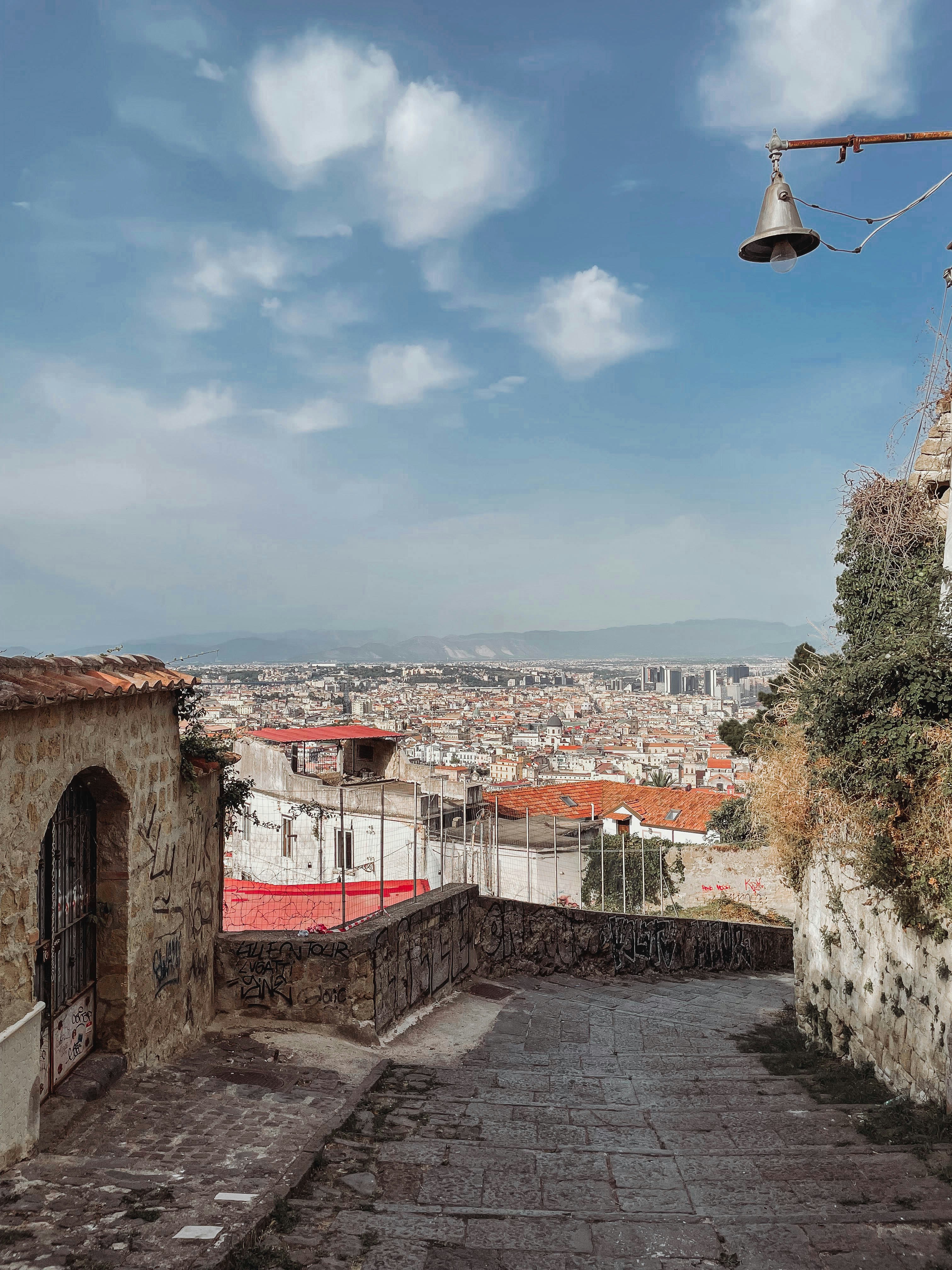 Terraced Staircase Framing a Red-Roofed City Under a Clear Blue Sky
