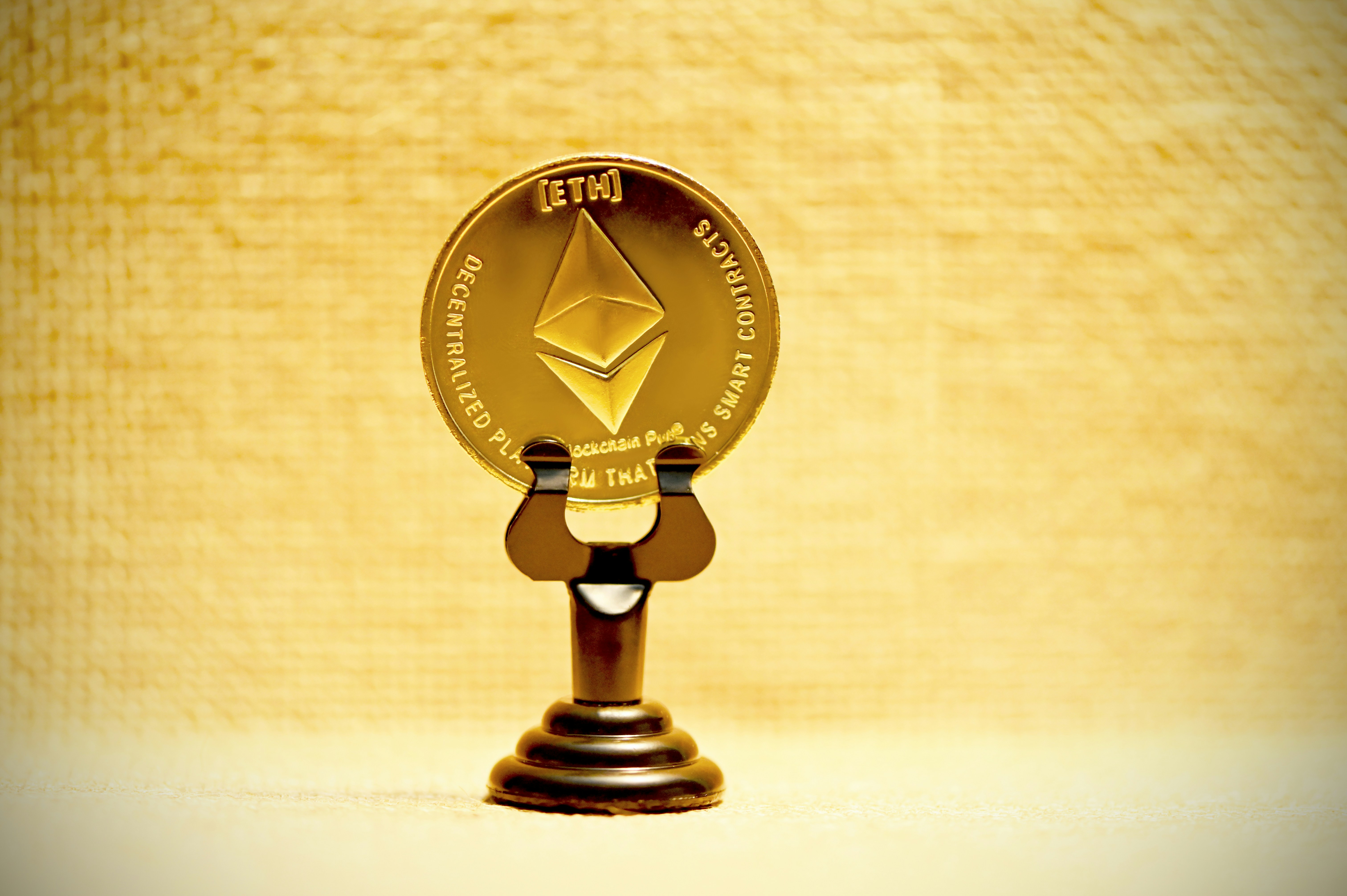 A gold ether coin on a wooden stand photo – Free Gold Image on Unsplash