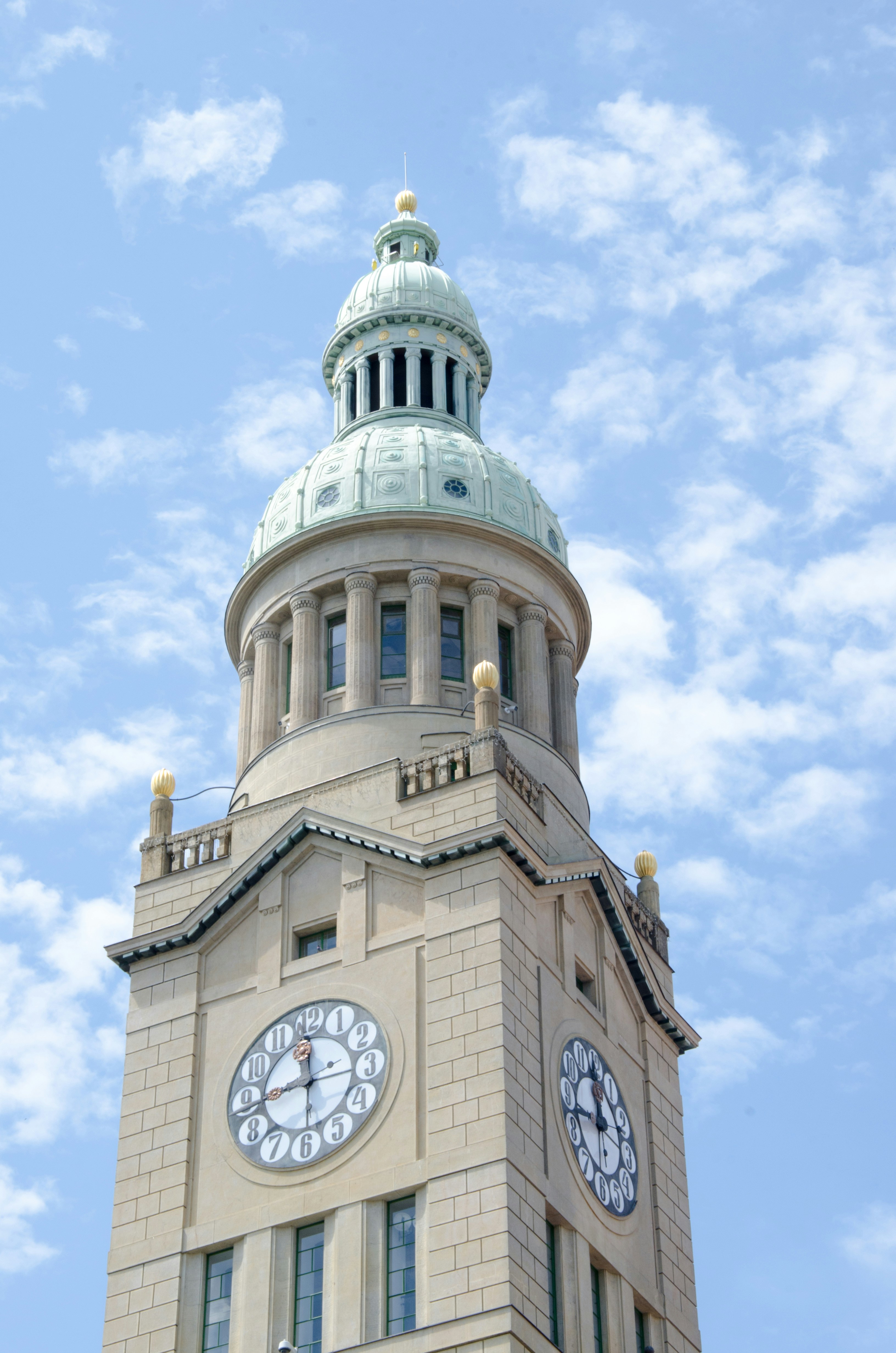 Historic clock tower with intricate architectural details and a vibrant blue sky backdrop.