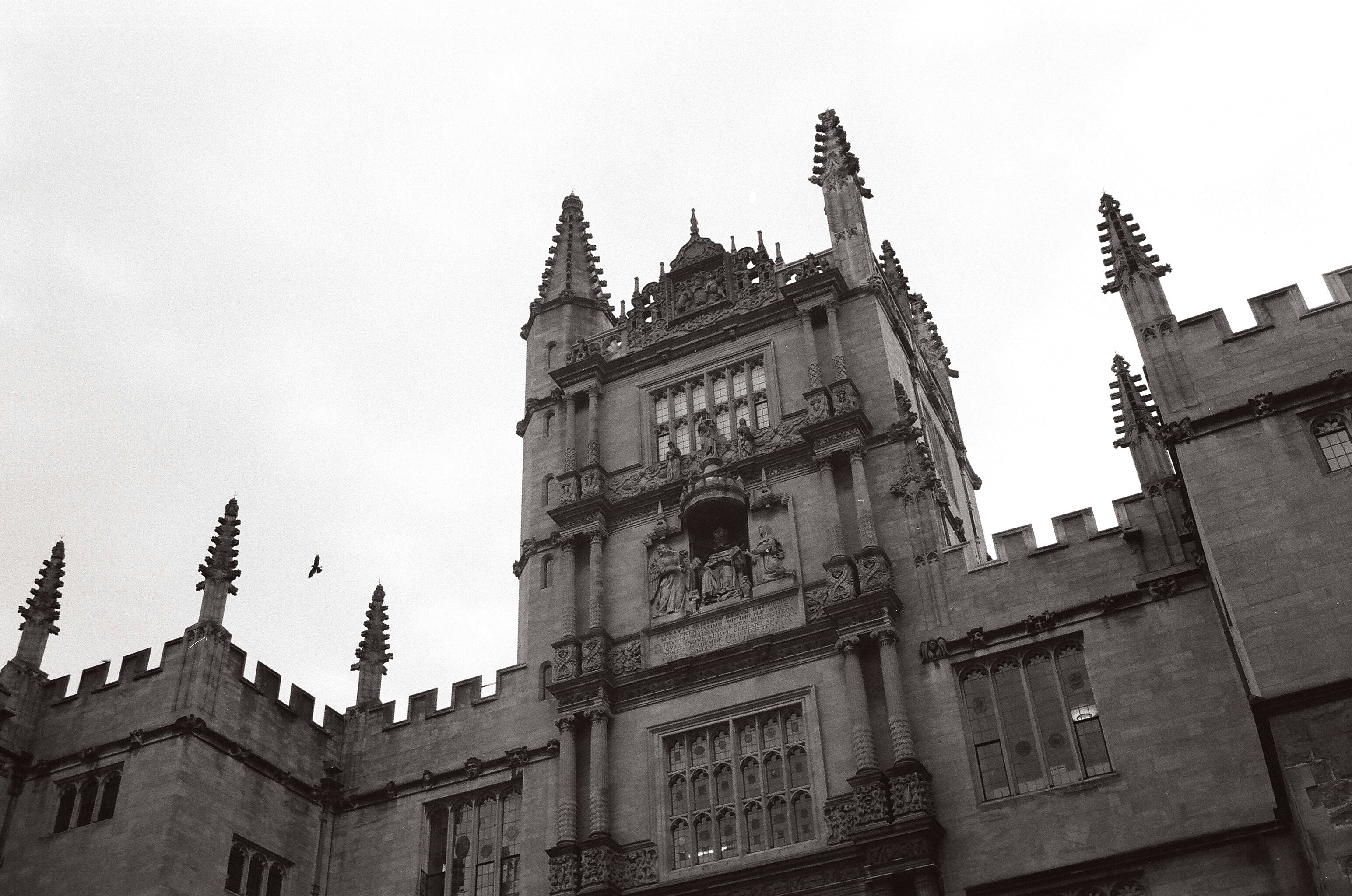 Imposing Gothic architecture featuring intricate spires and detailed stonework under a cloudy sky.
