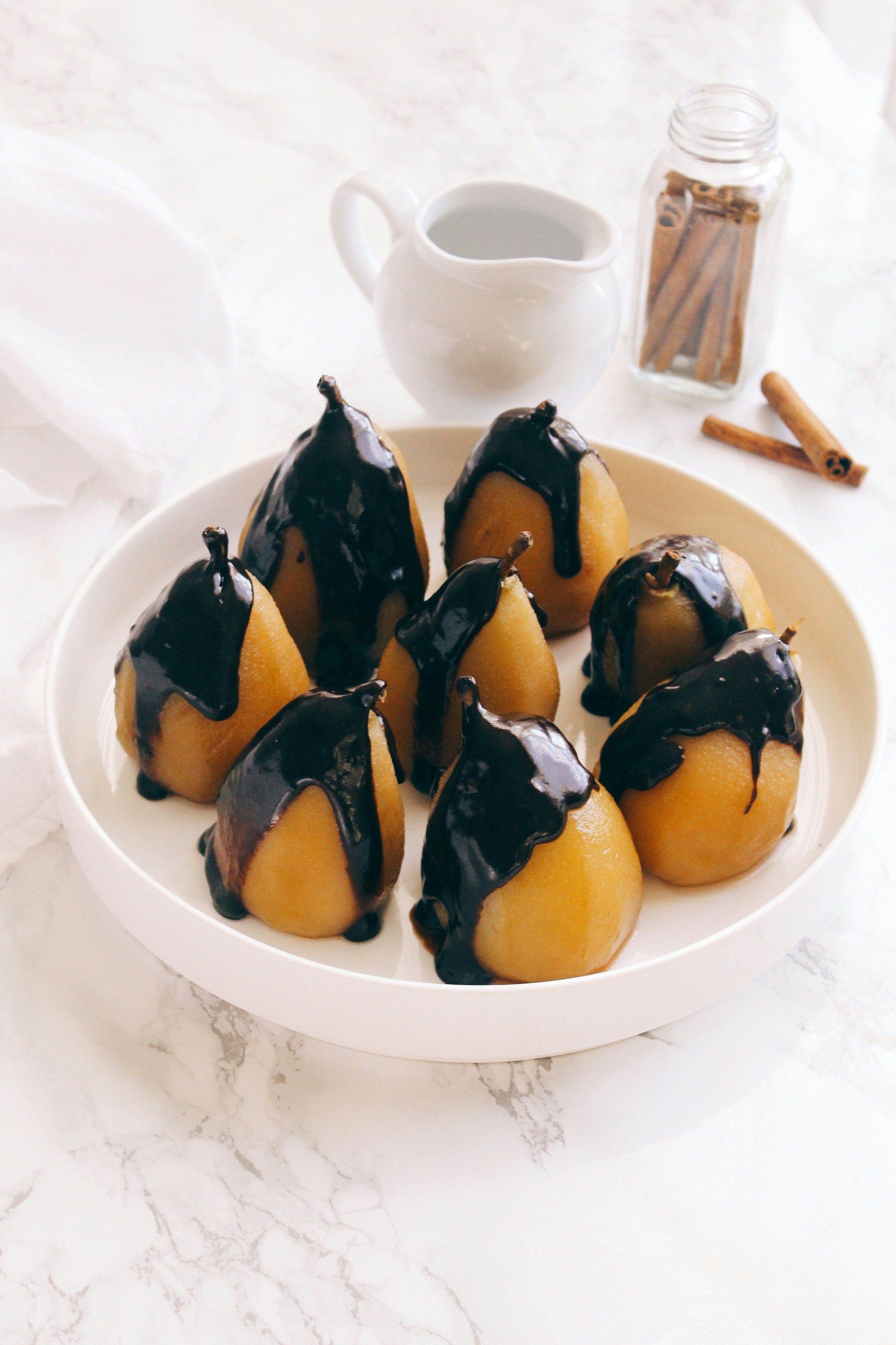 Dark-Drizzled Pears on a White Marble Stage