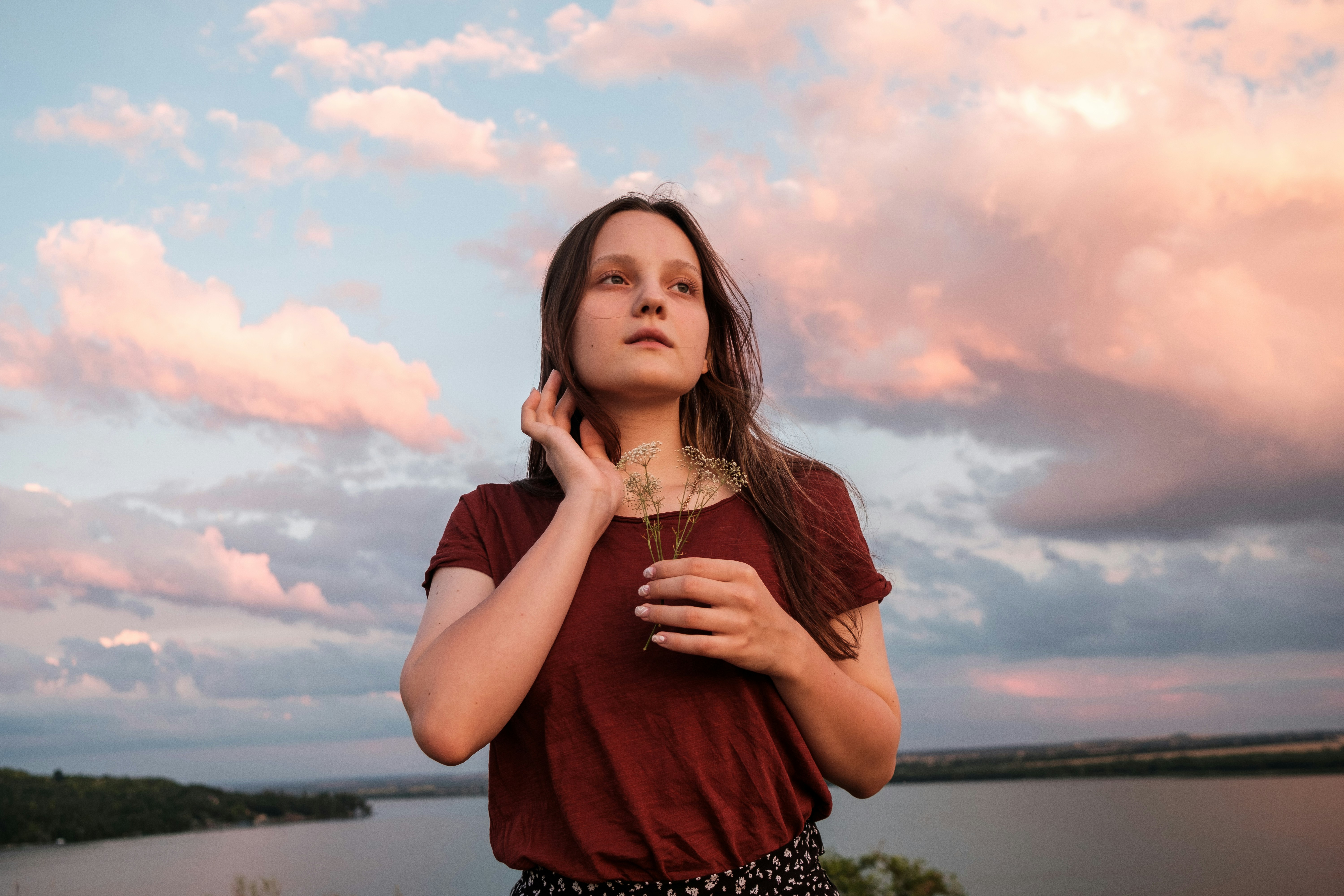 woman in brown shirt standing near body of water during daytime