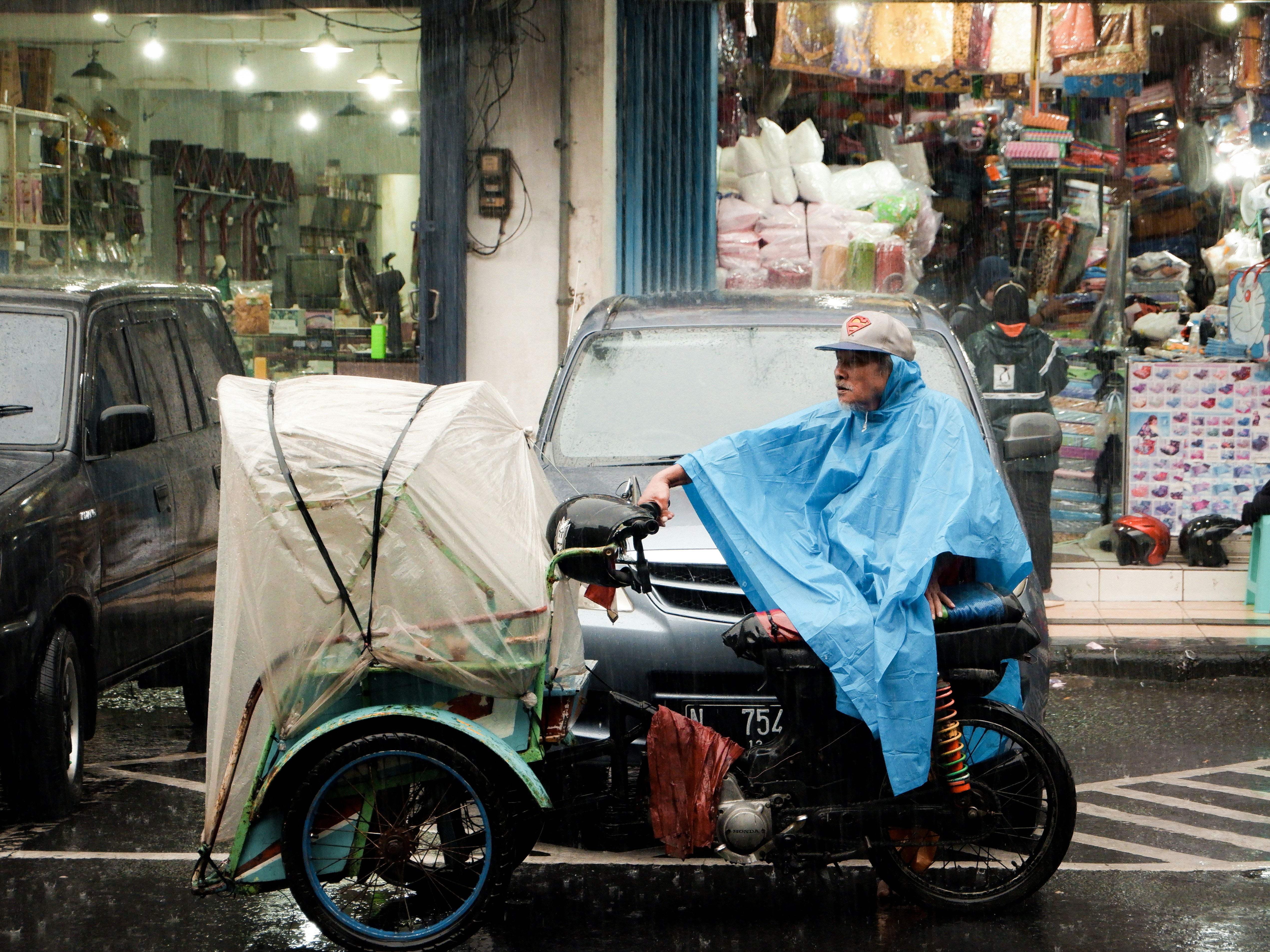 Man Riding a Rickshaw On A Rainy Day