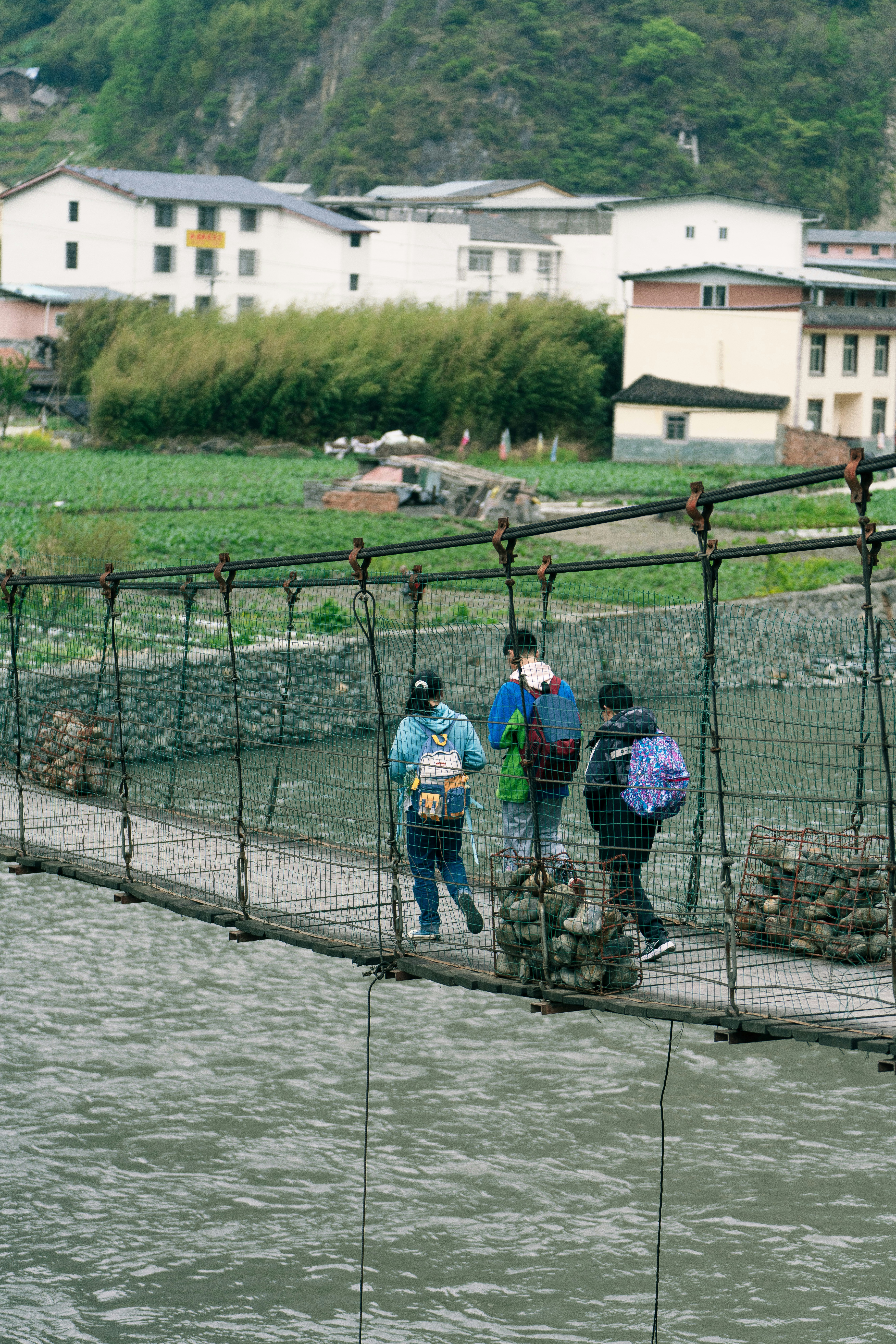 Bridge Crossing: A Small Group on a Wobbly Footpath Over a River