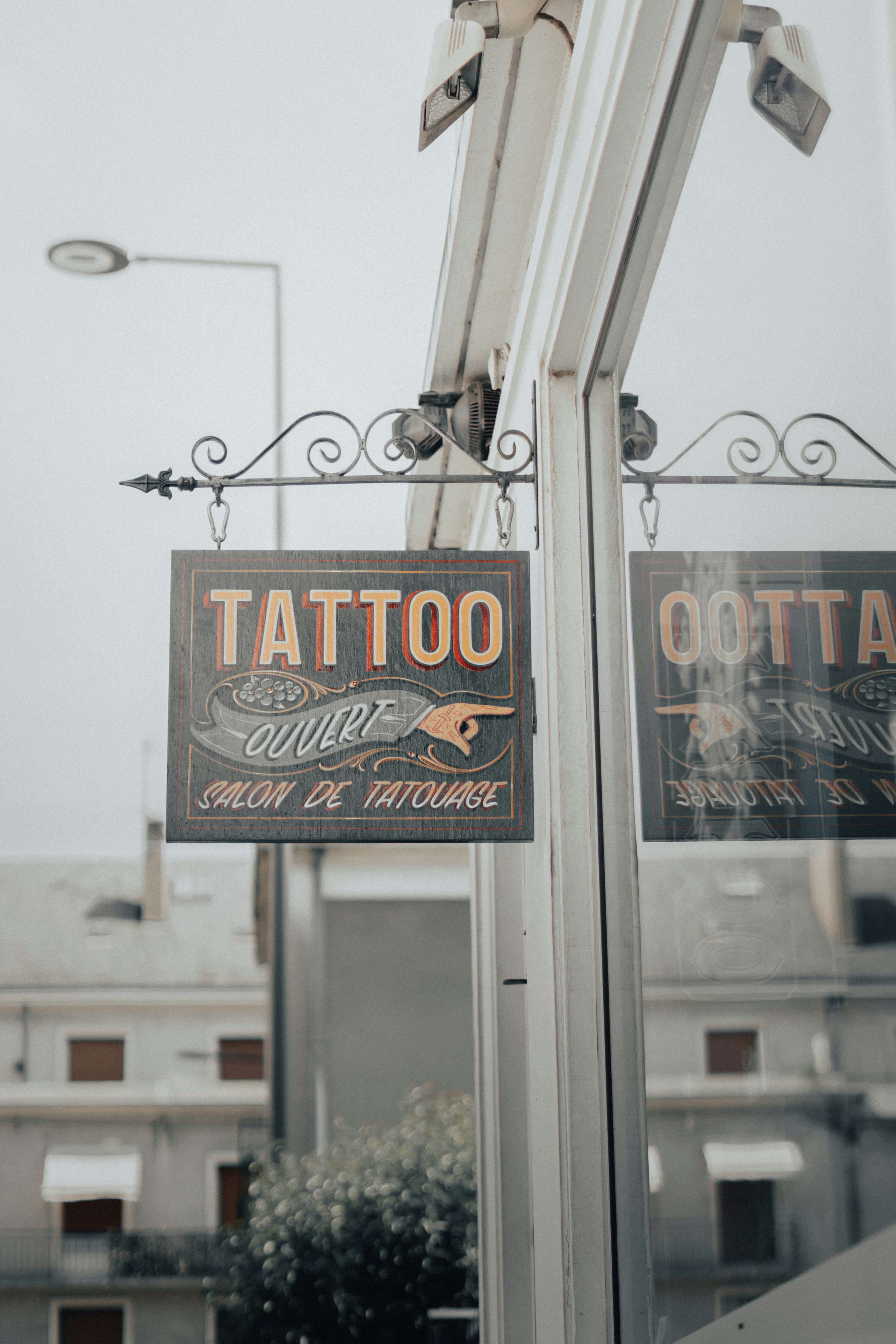 Tattoo Sign Framed by Glass and Ornate Ironwork