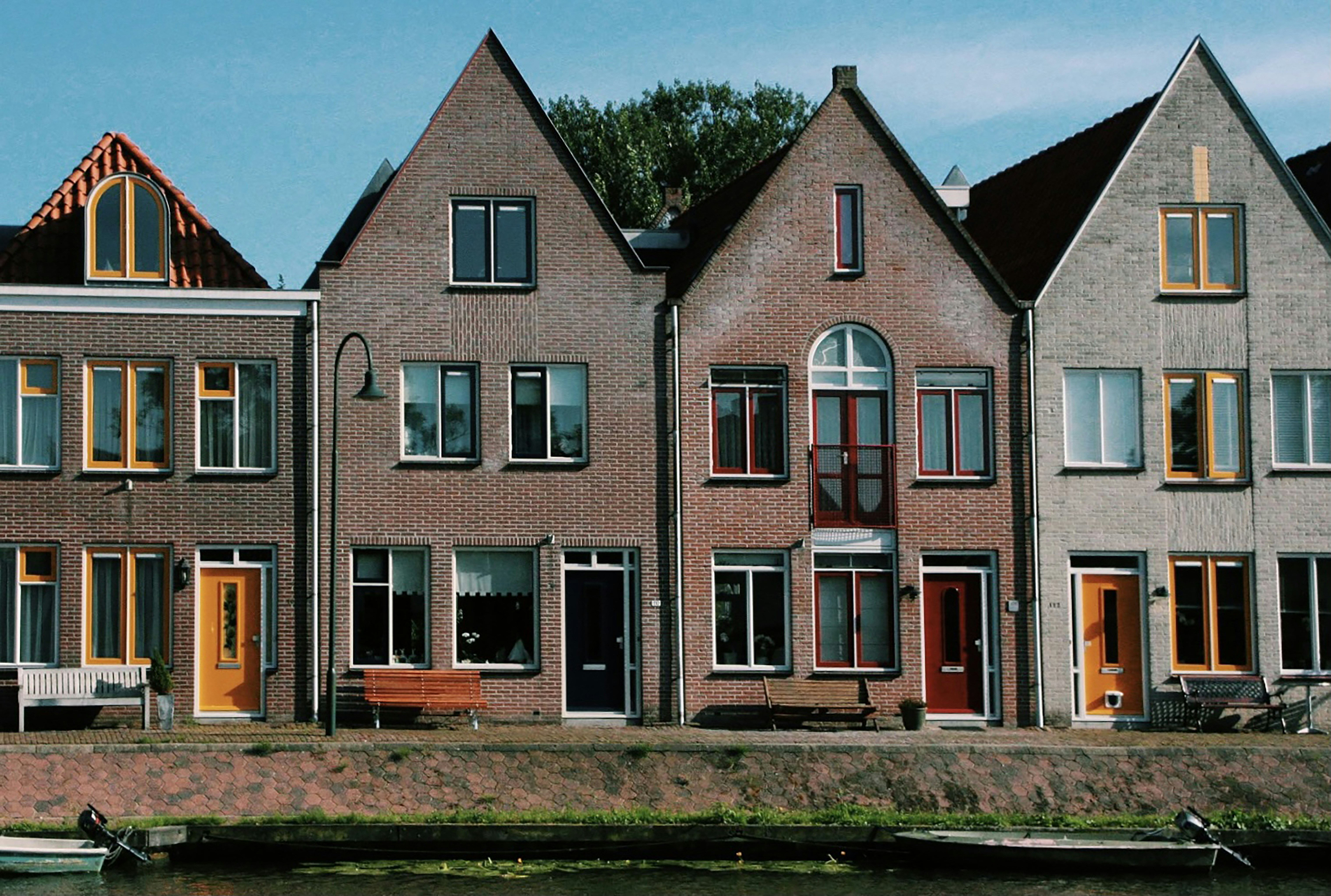 Colorful canal-side houses showcasing unique architectural details along a tranquil waterway.