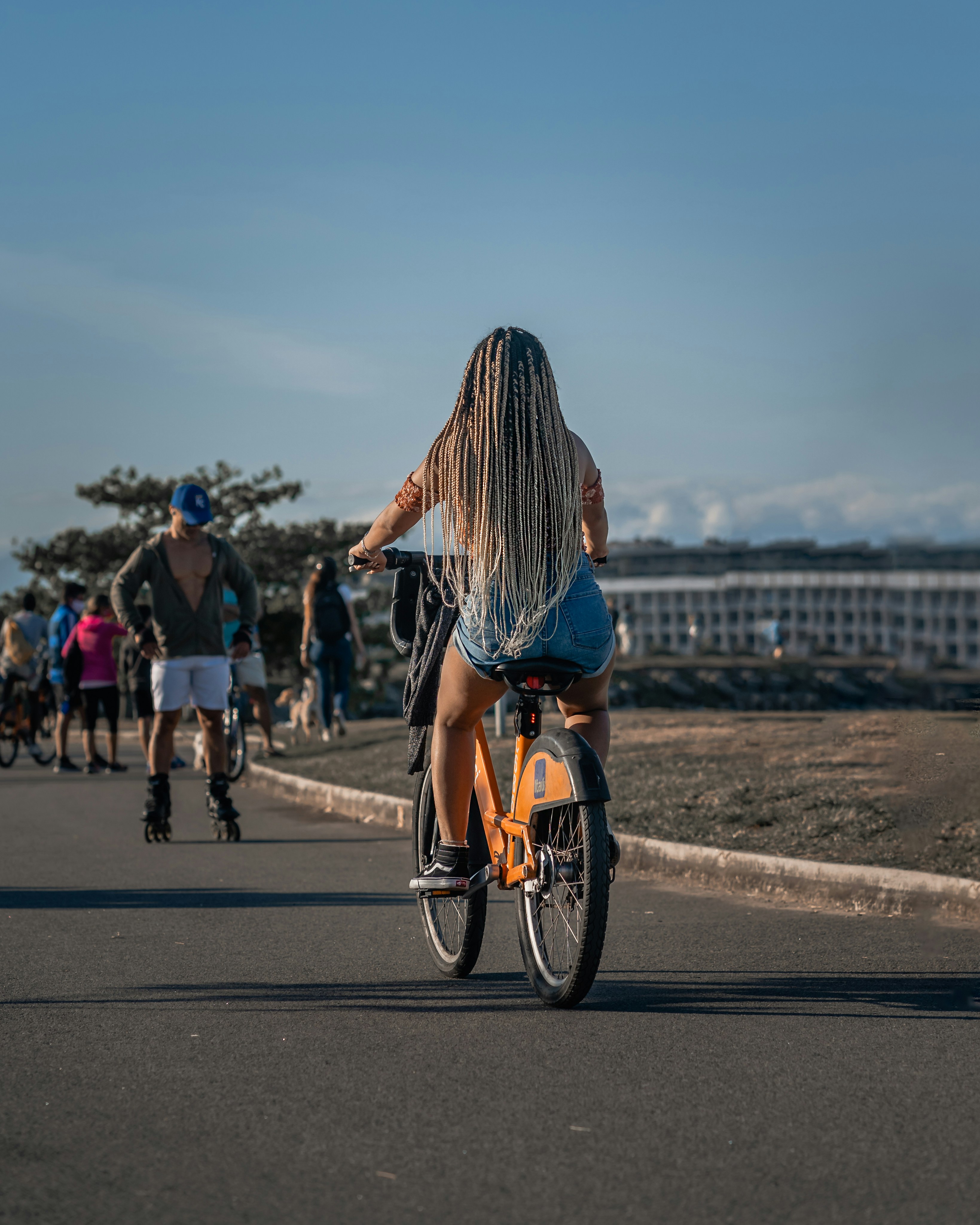 woman in black and white striped long sleeve shirt riding bicycle on road during daytime