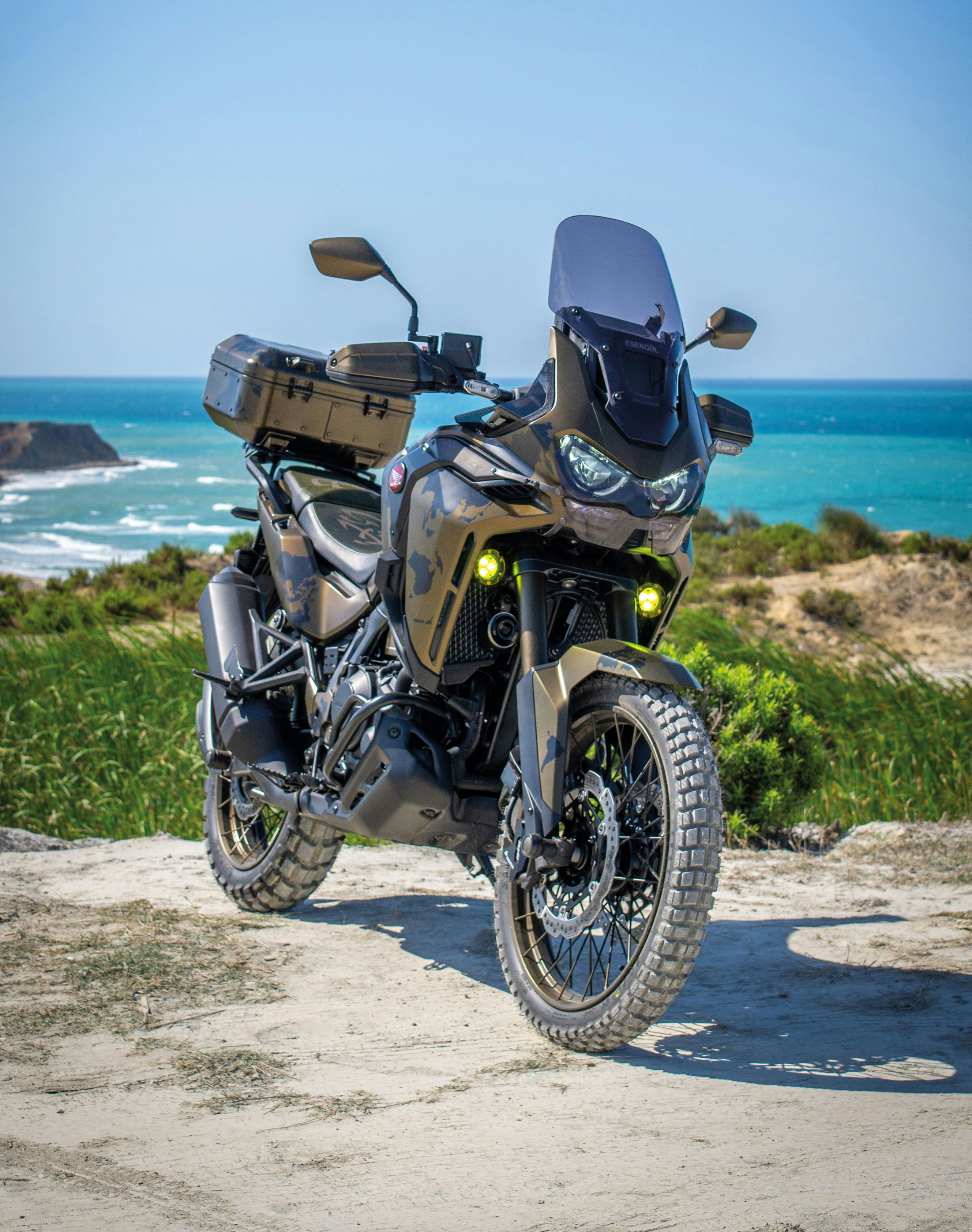 Black and gray motorcycle on brown sand near body of water during ...