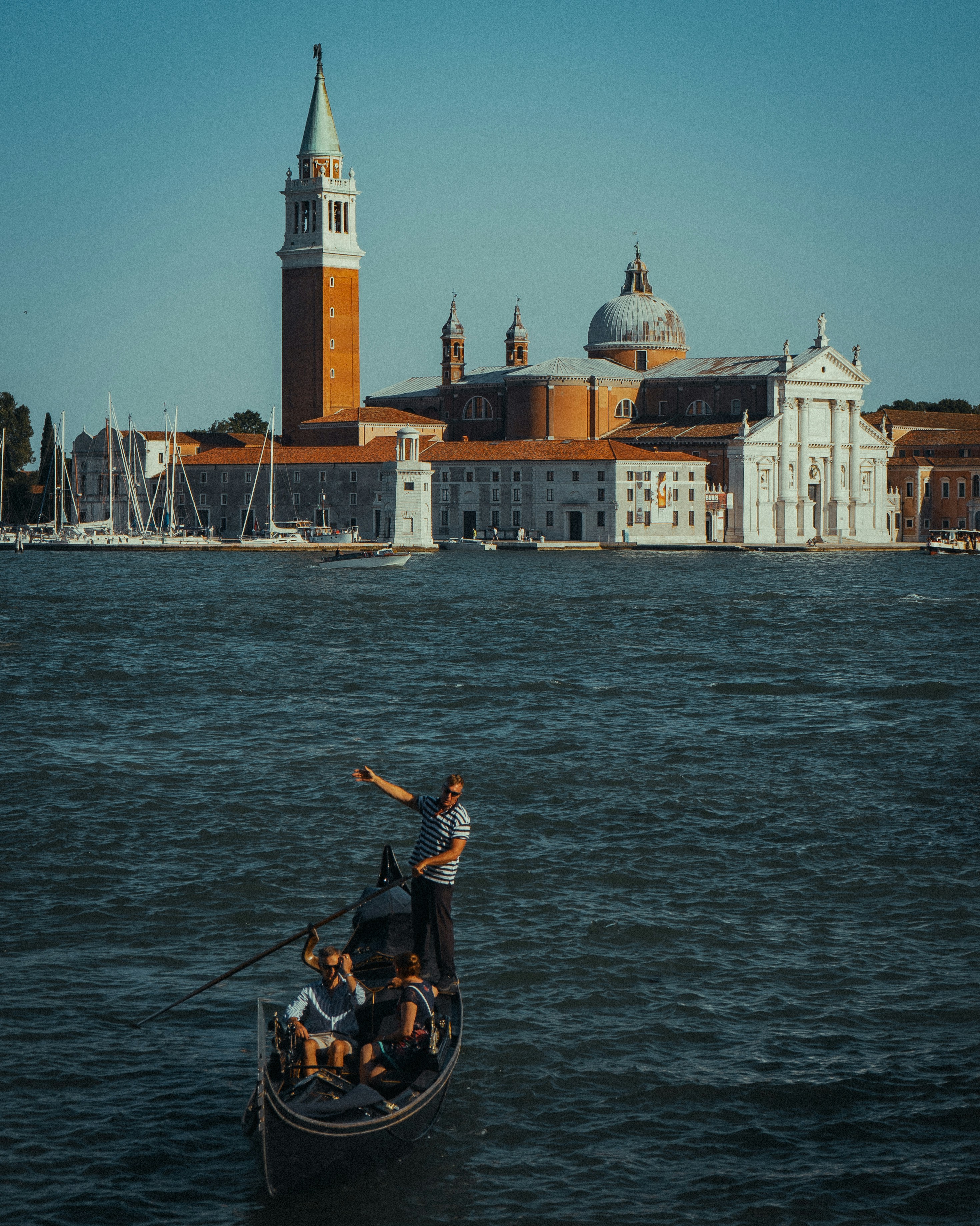 Gondola gliding through the waters of Venice, with iconic architecture in the background. The scene captures the essence of Venetian life.