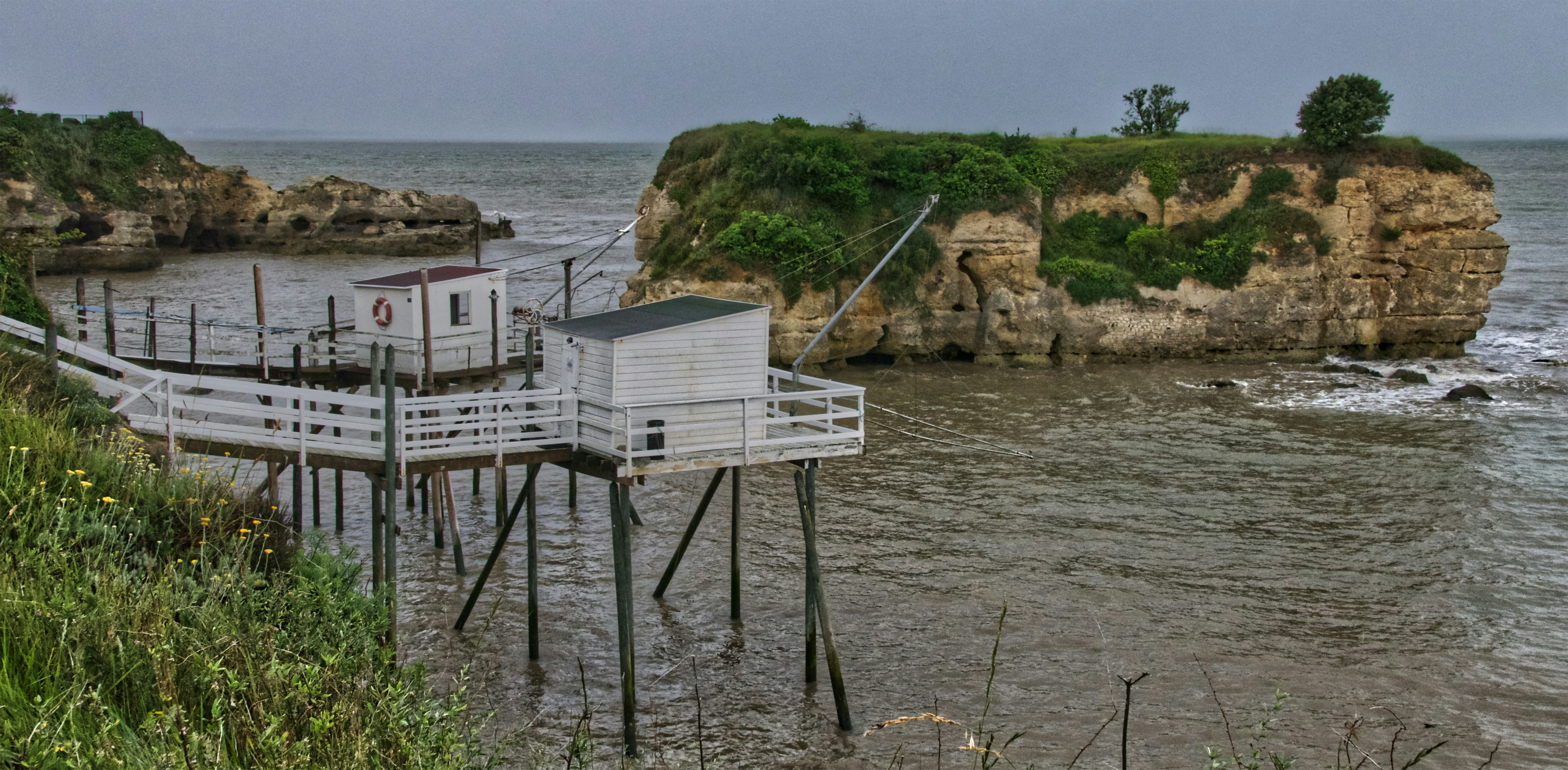 Stilted Harborage: White Cabins Lean into a Quiet Coastal Calm