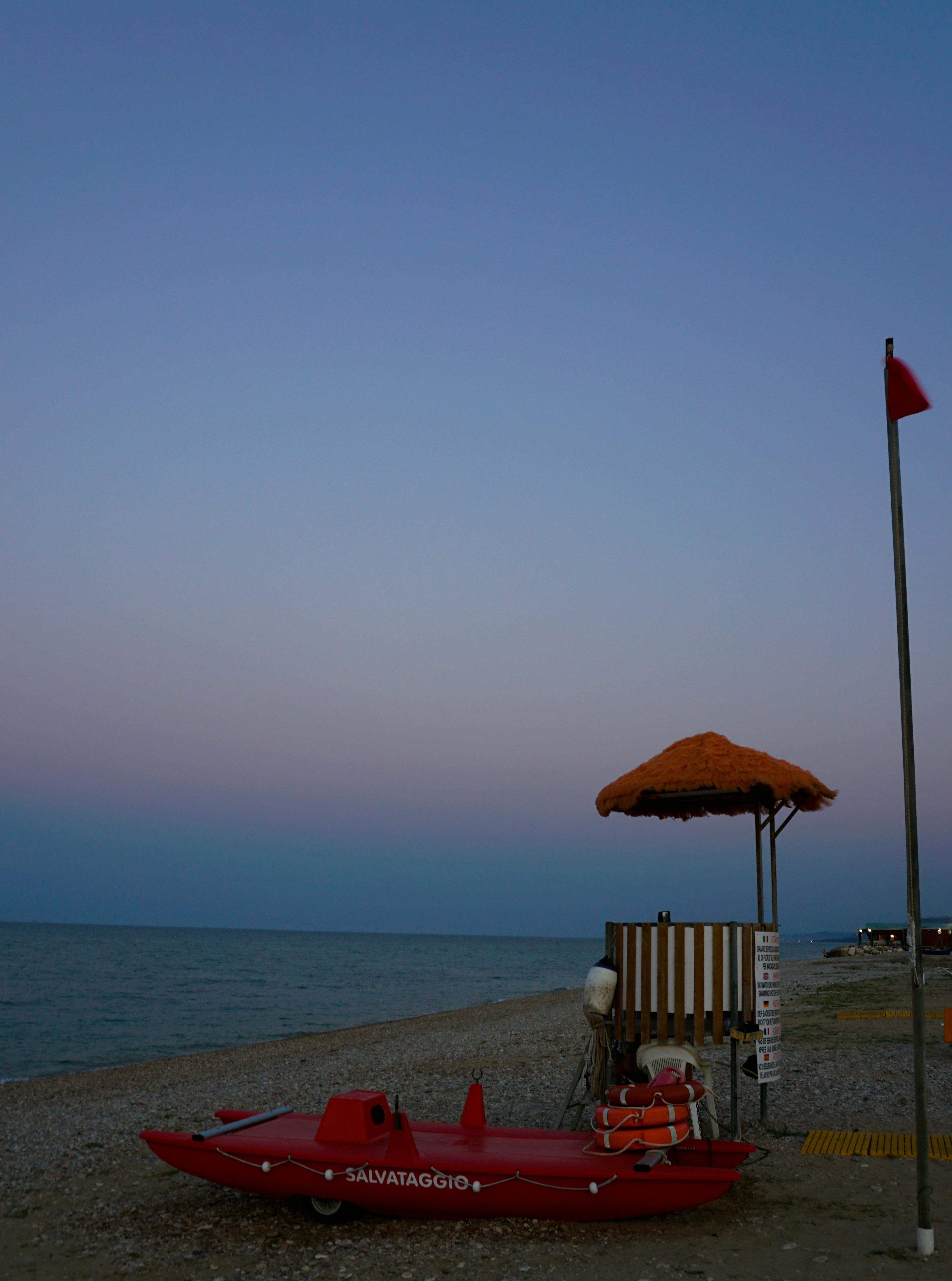 Red Lifeboat at Dusk: A Quiet Beach Vigil