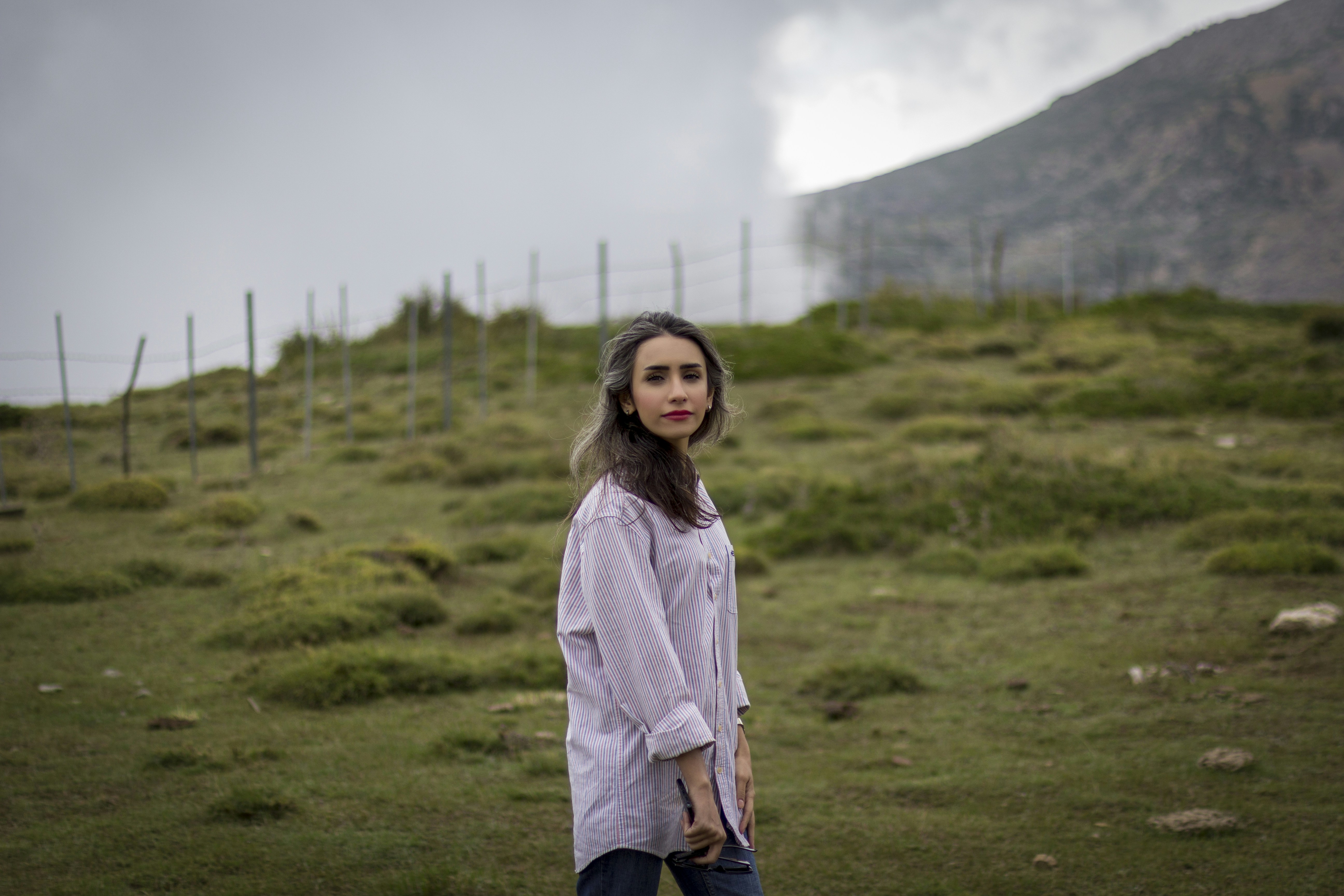 woman in white long sleeve shirt standing on green grass field during daytime