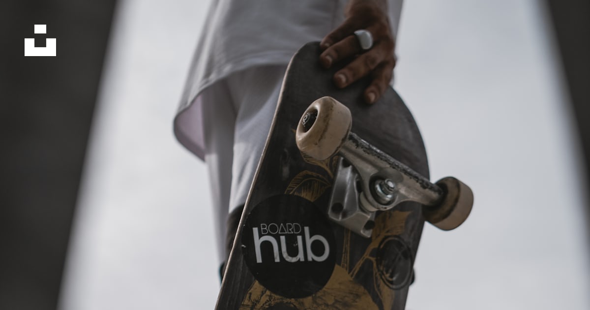Man In White Shirt Holding Brown And Black Skateboard Photo Free